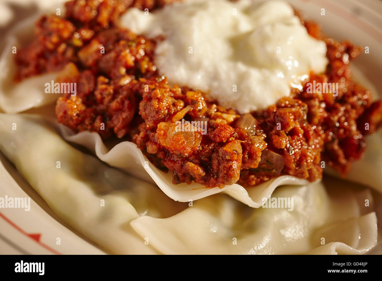 a plate of aushak, vegetable dumplings with meat sauce, from ...