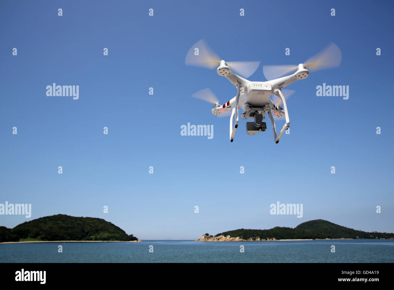 White drone quad copter with flying in the clear blue sky Stock Photo ...