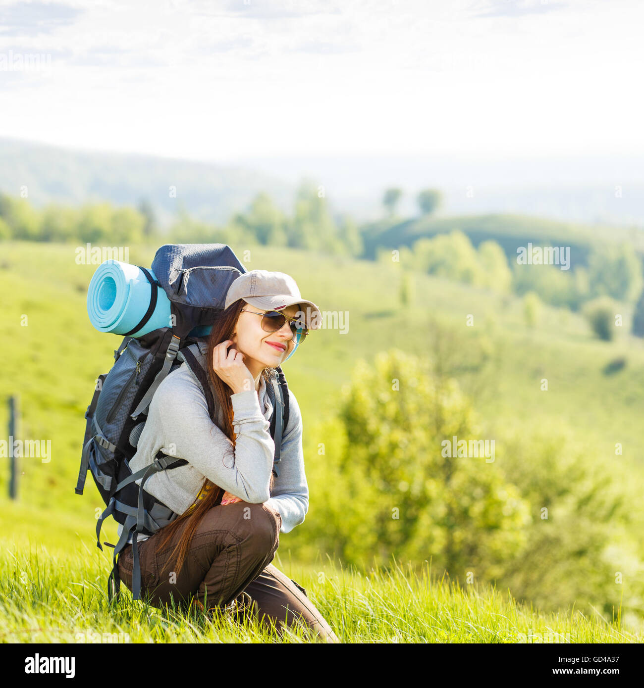 Young backpacking woman rest at the hill. Smiling girl with backpack ...