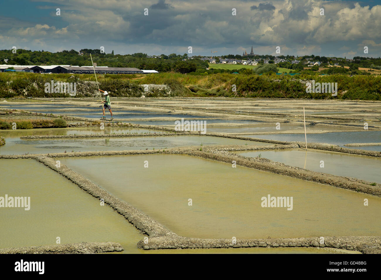 Breton salt marshes with Paludier scraping sea salt from the lagoons in ...