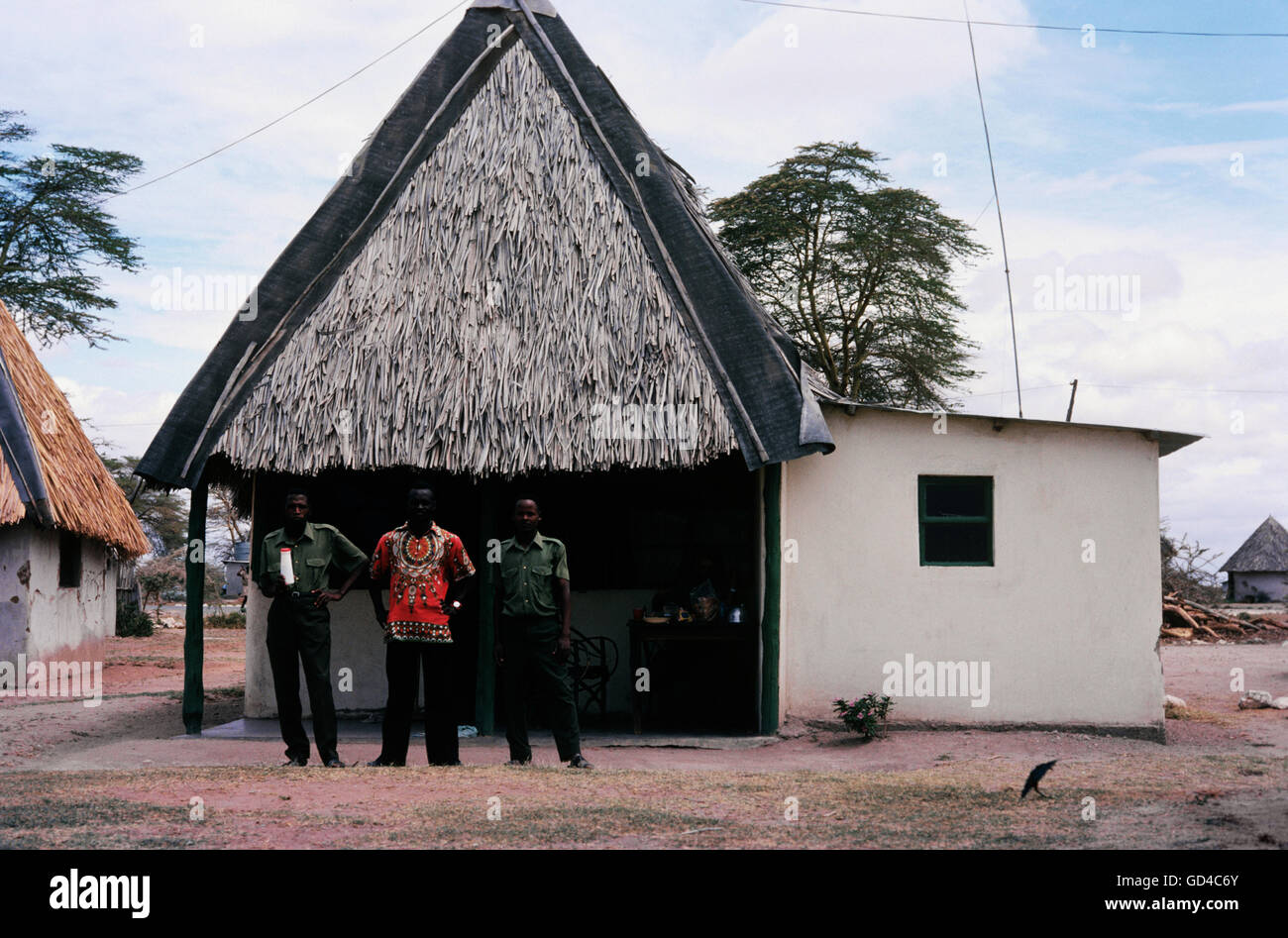 Three people in front of a cottage Stock Photo - Alamy
