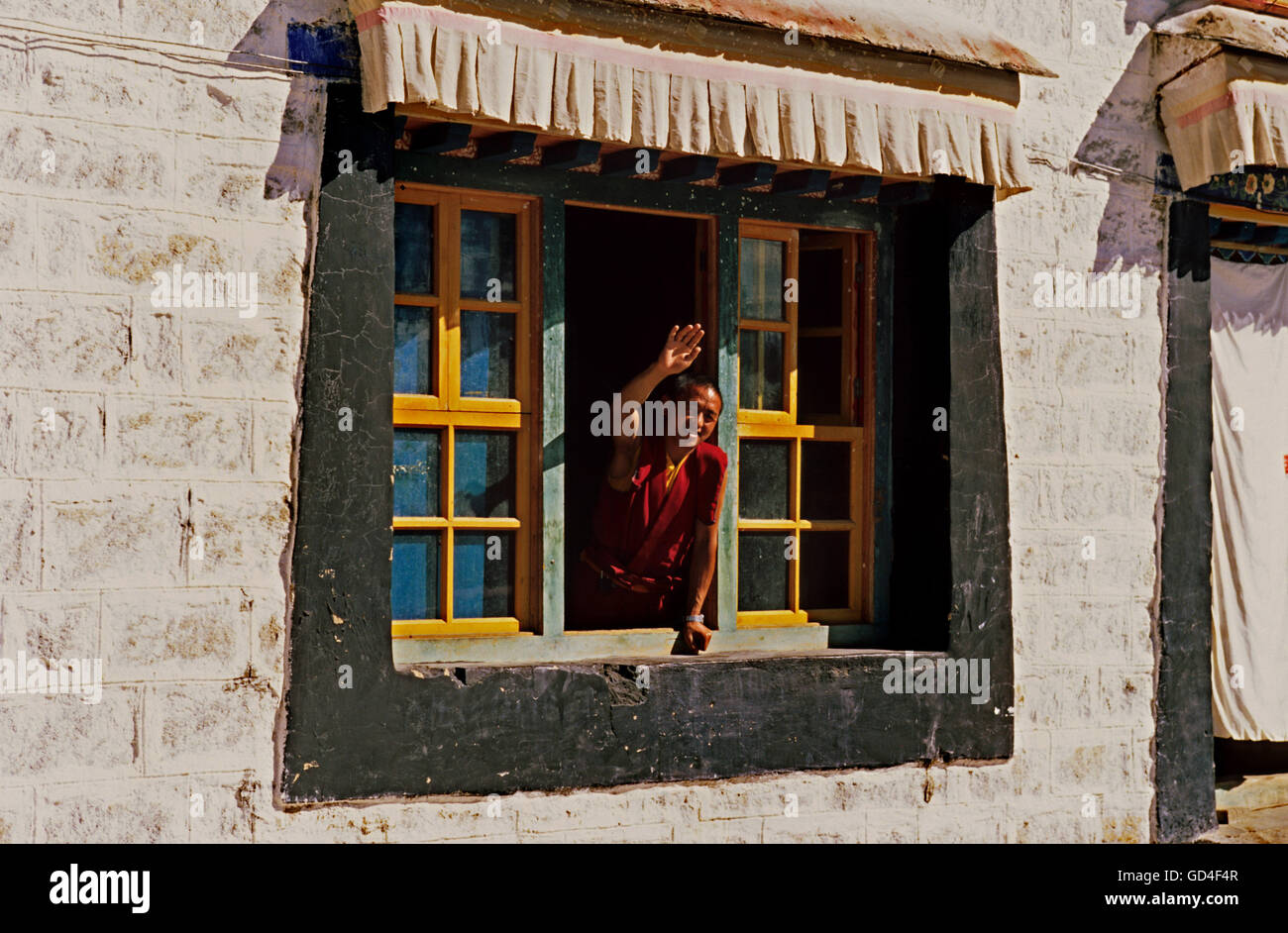 Monk waving from a window Stock Photo - Alamy