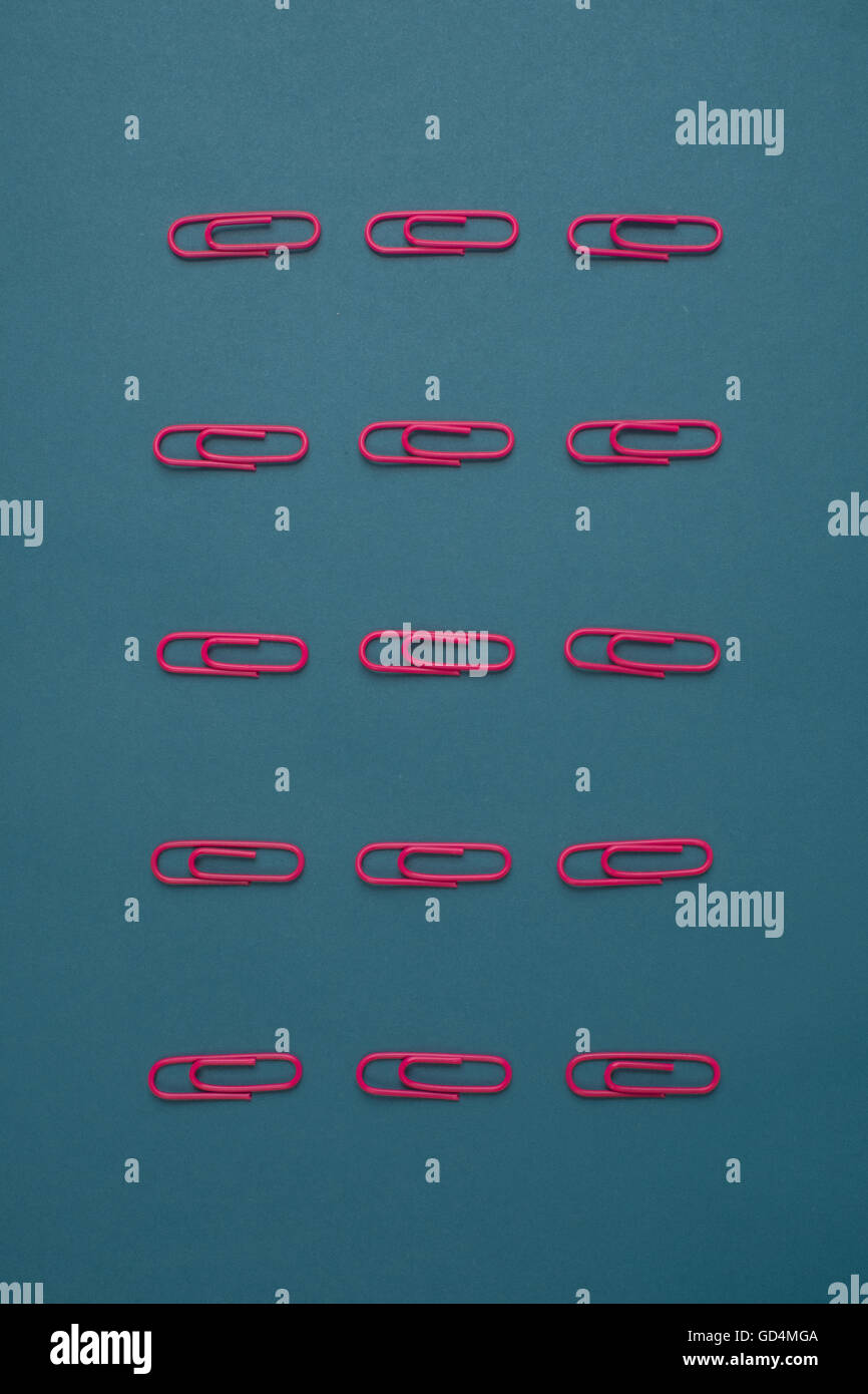 Close-up of pink paper clips on blue background Stock Photo - Alamy