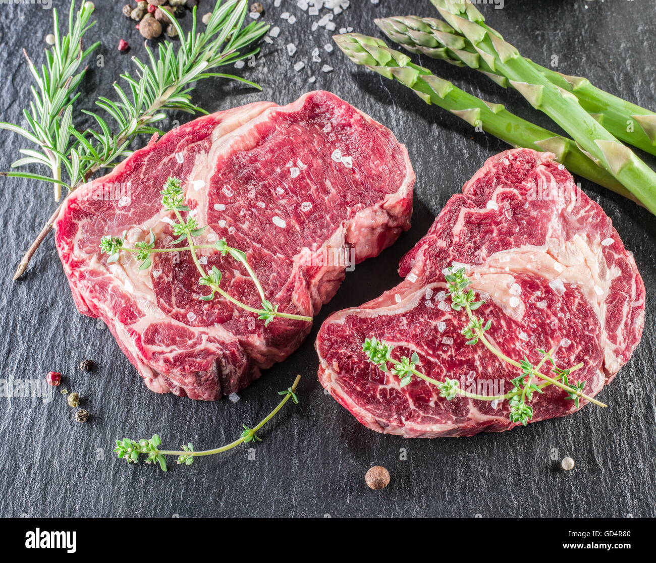 Rib eye steak with spices on the black background Stock Photo - Alamy