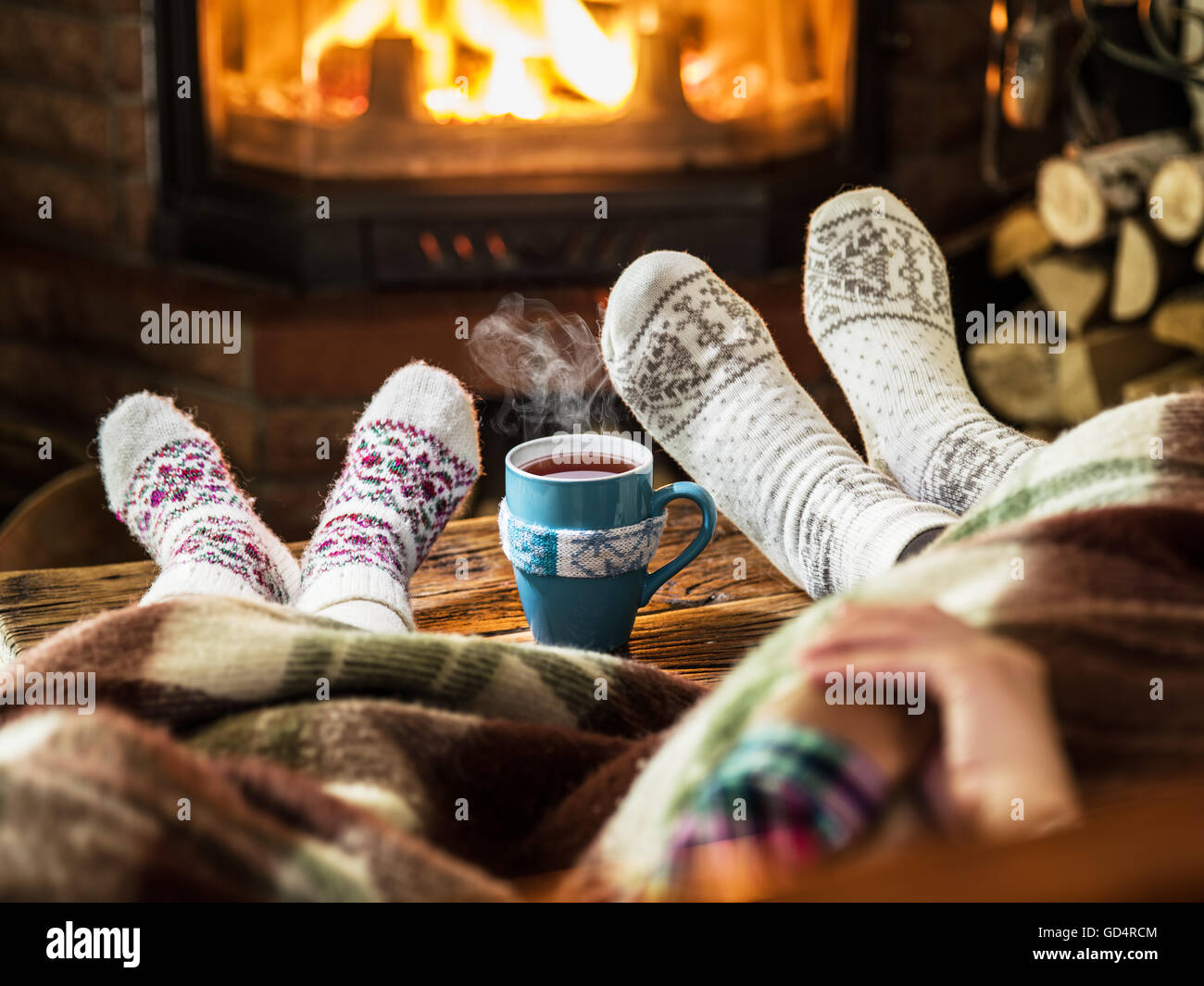 Warming and relaxing near fireplace. Mother and daughter holding hands ...