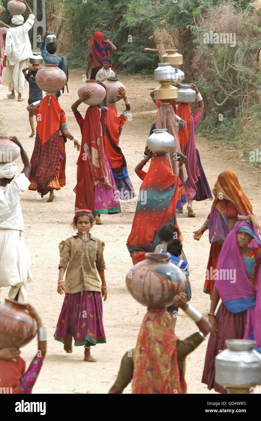 Villagers carrying water pots Stock Photo - Alamy