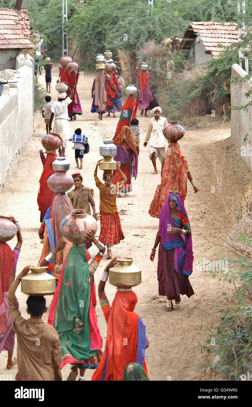 Villagers carrying water pots Stock Photo - Alamy