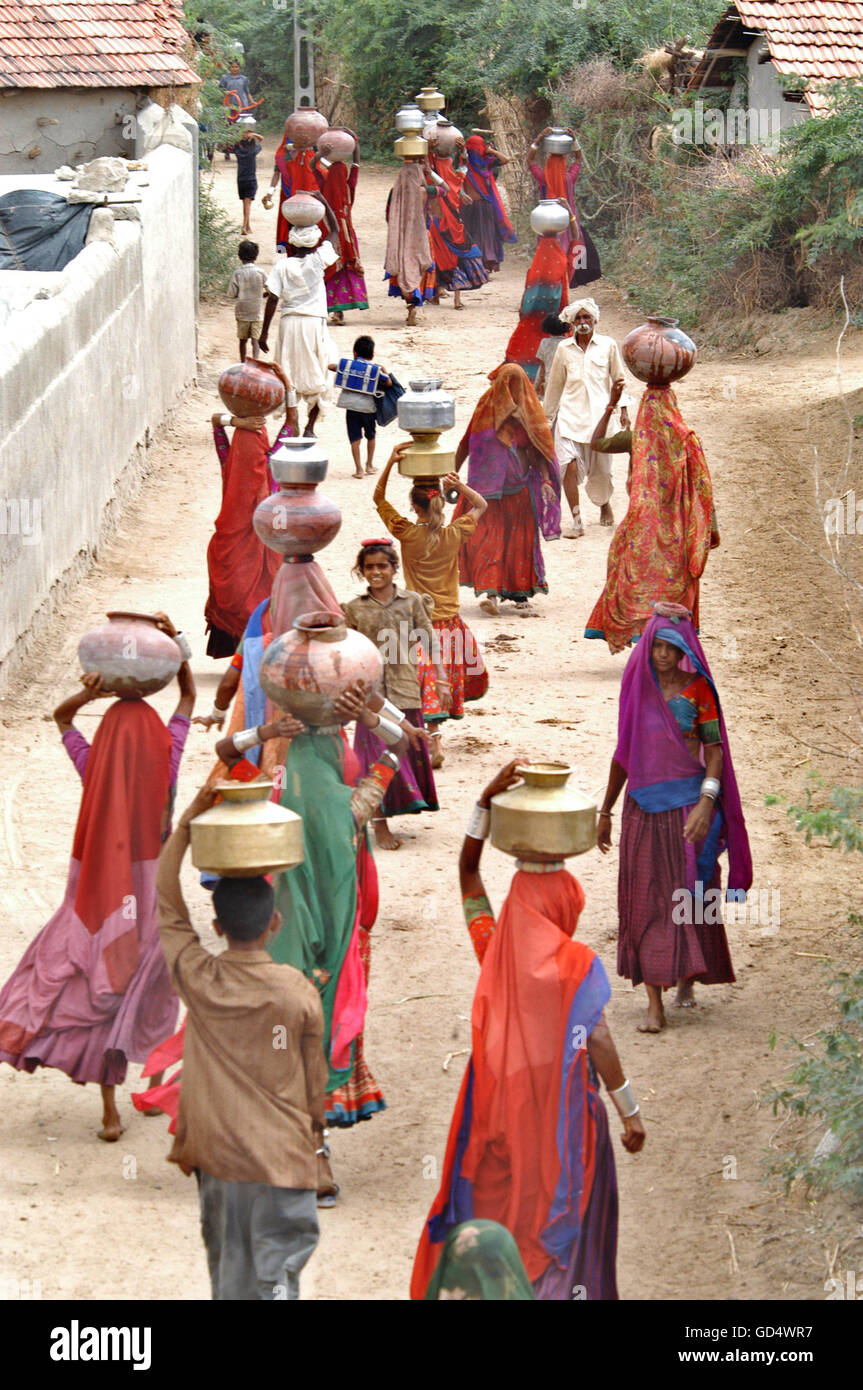 Villagers carrying water pots Stock Photo - Alamy