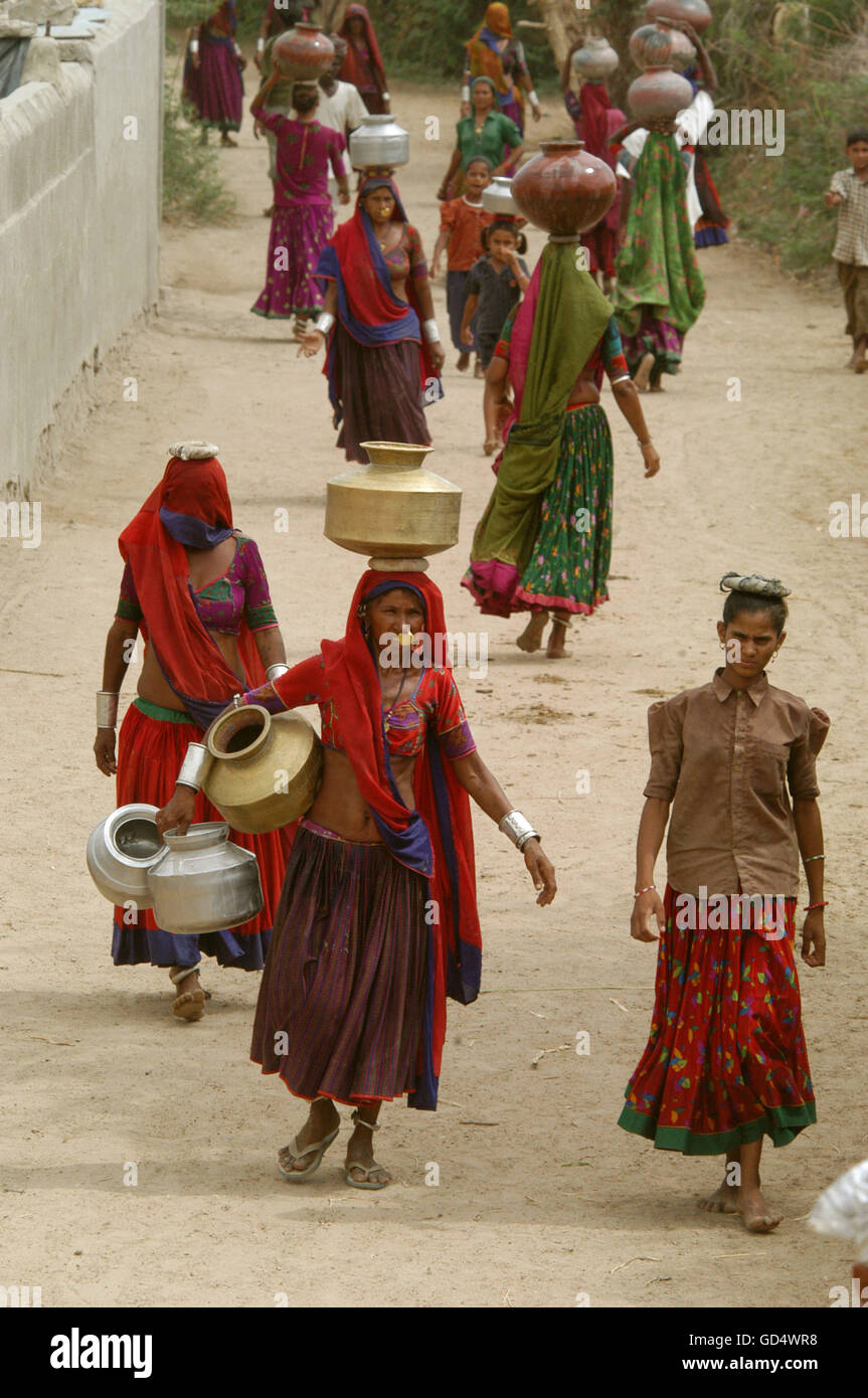 Villagers carrying water pots Stock Photo - Alamy