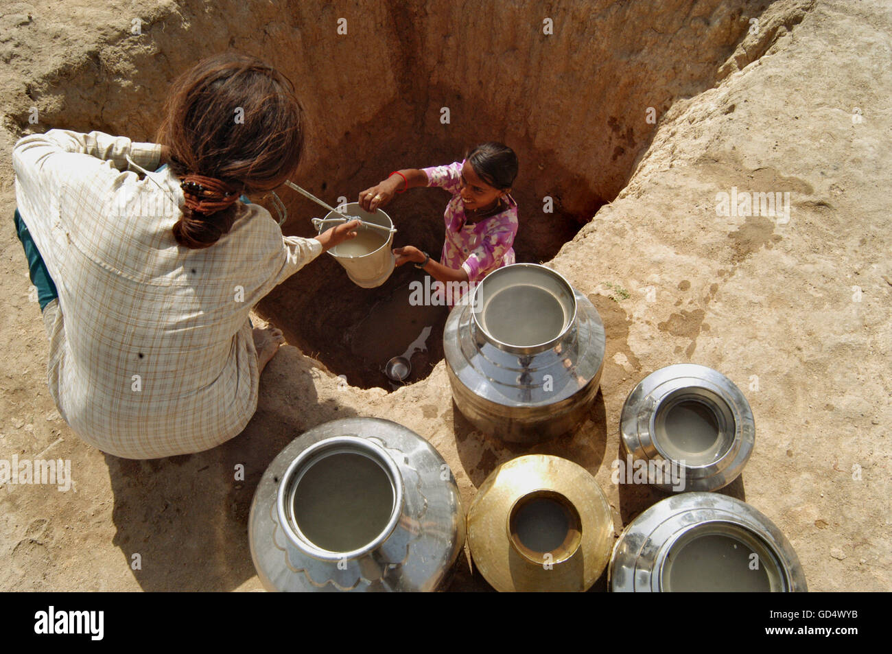 Women diging out water Stock Photo - Alamy