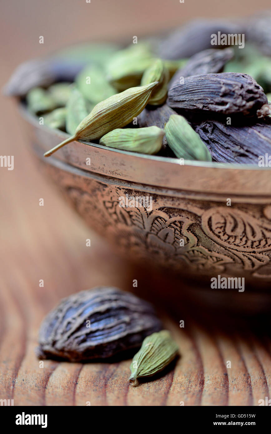 Gruener und schwarzer kardamom in schale hi-res stock photography and ...