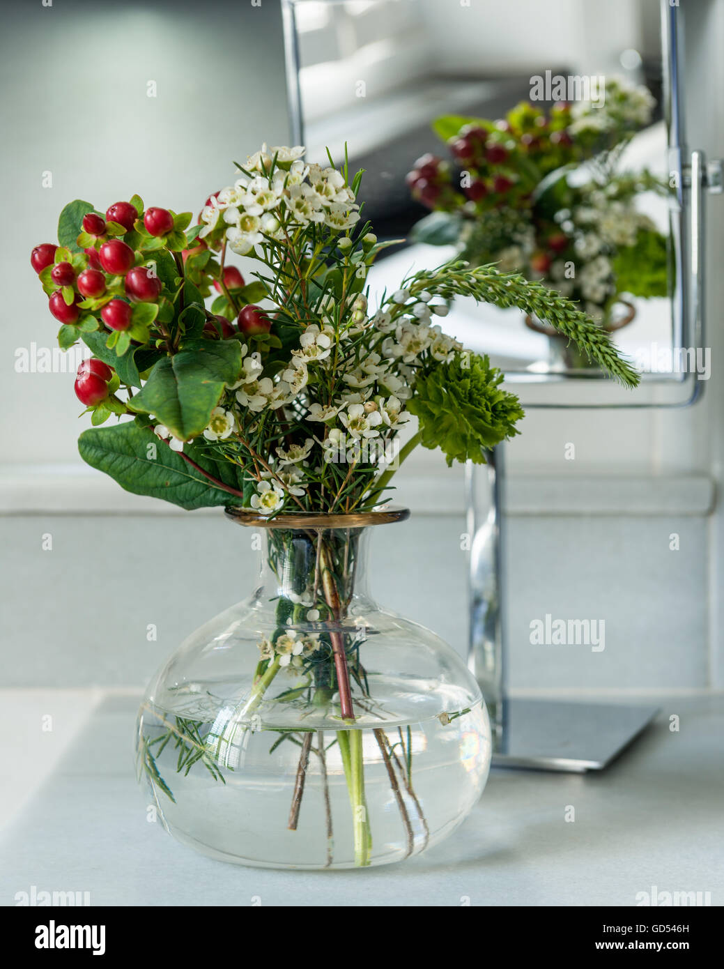 Mix of flowers and sprigs in small glass vase Stock Photo - Alamy
