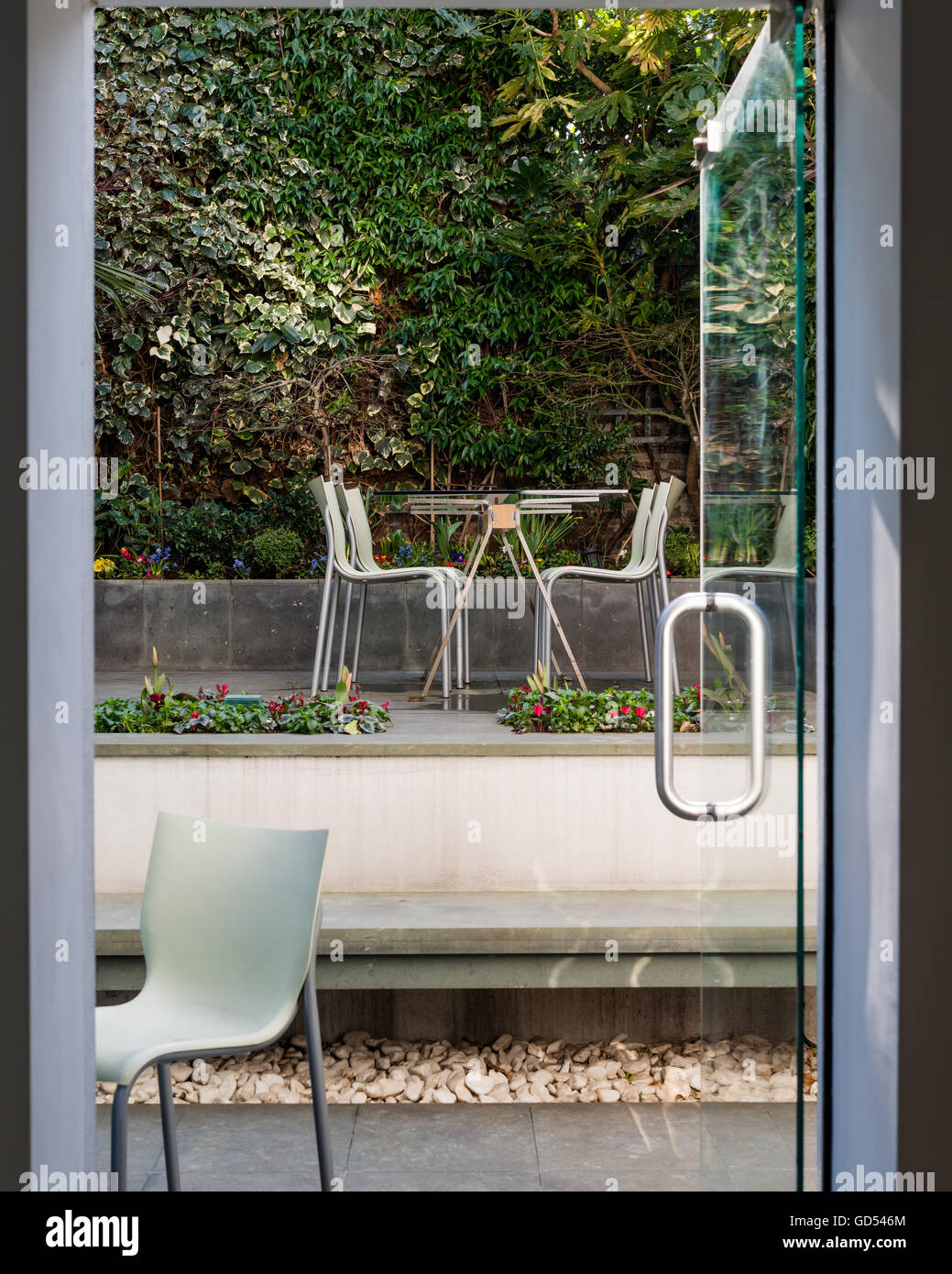 View through open door to raised garden area with seating Stock Photo ...