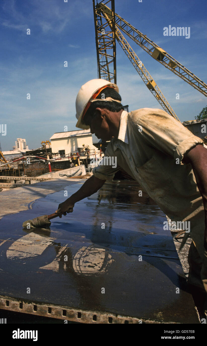 Worker oiling a metal board Stock Photo - Alamy