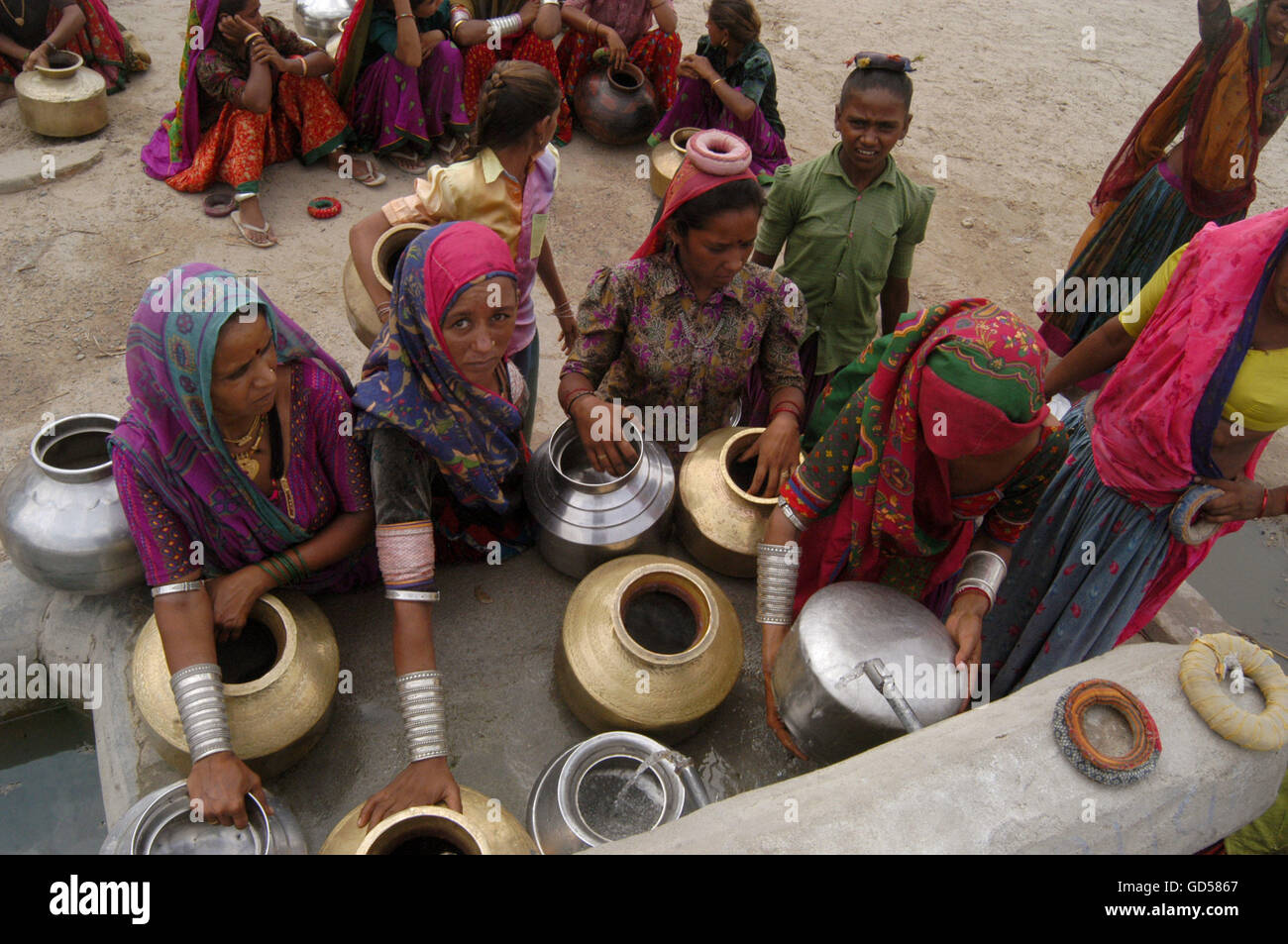 Women sitting with a water pot Stock Photo - Alamy