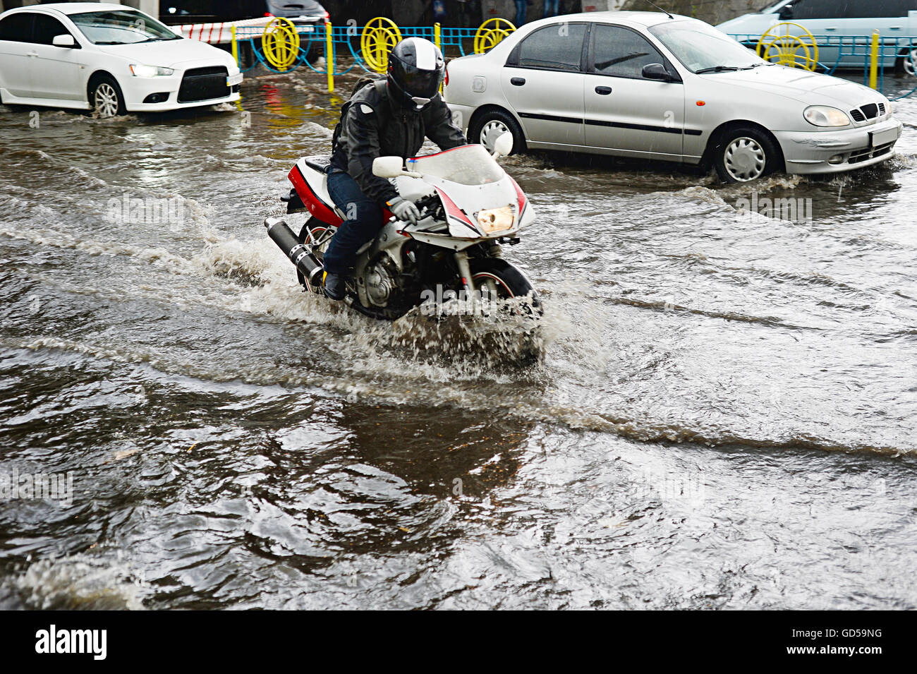 Motorcycle and cars on flooded road during the heavy rain Stock Photo ...