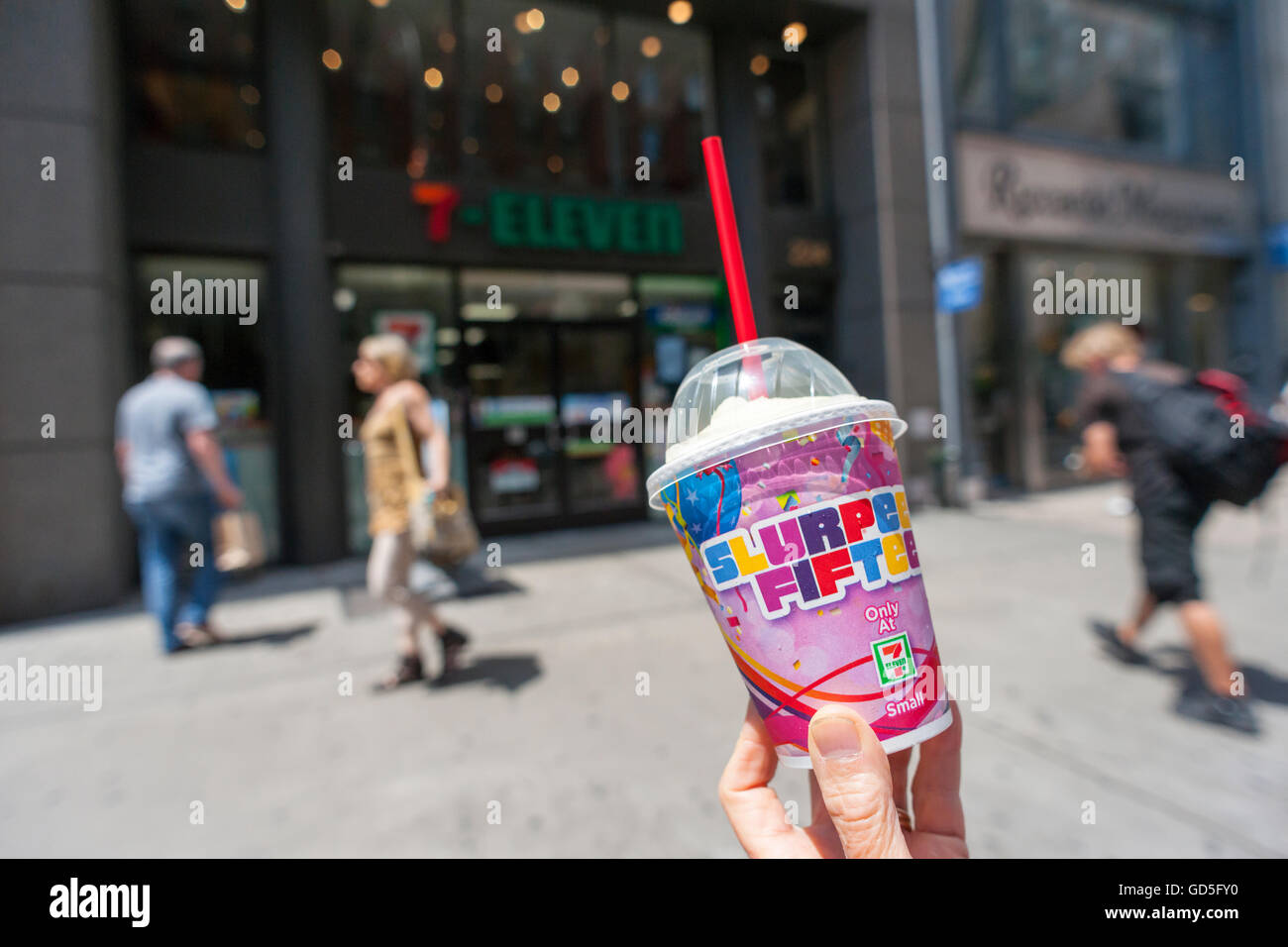 A Slurpee lover displays her free drink outside a 7-Eleven store in New ...