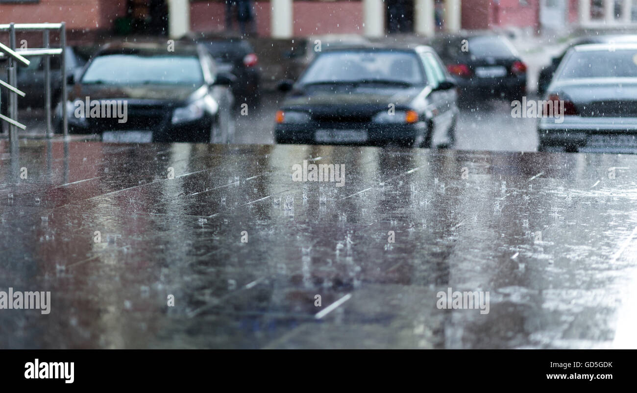 Heavy rain drops on asphalt with parked cars on background Stock Photo ...