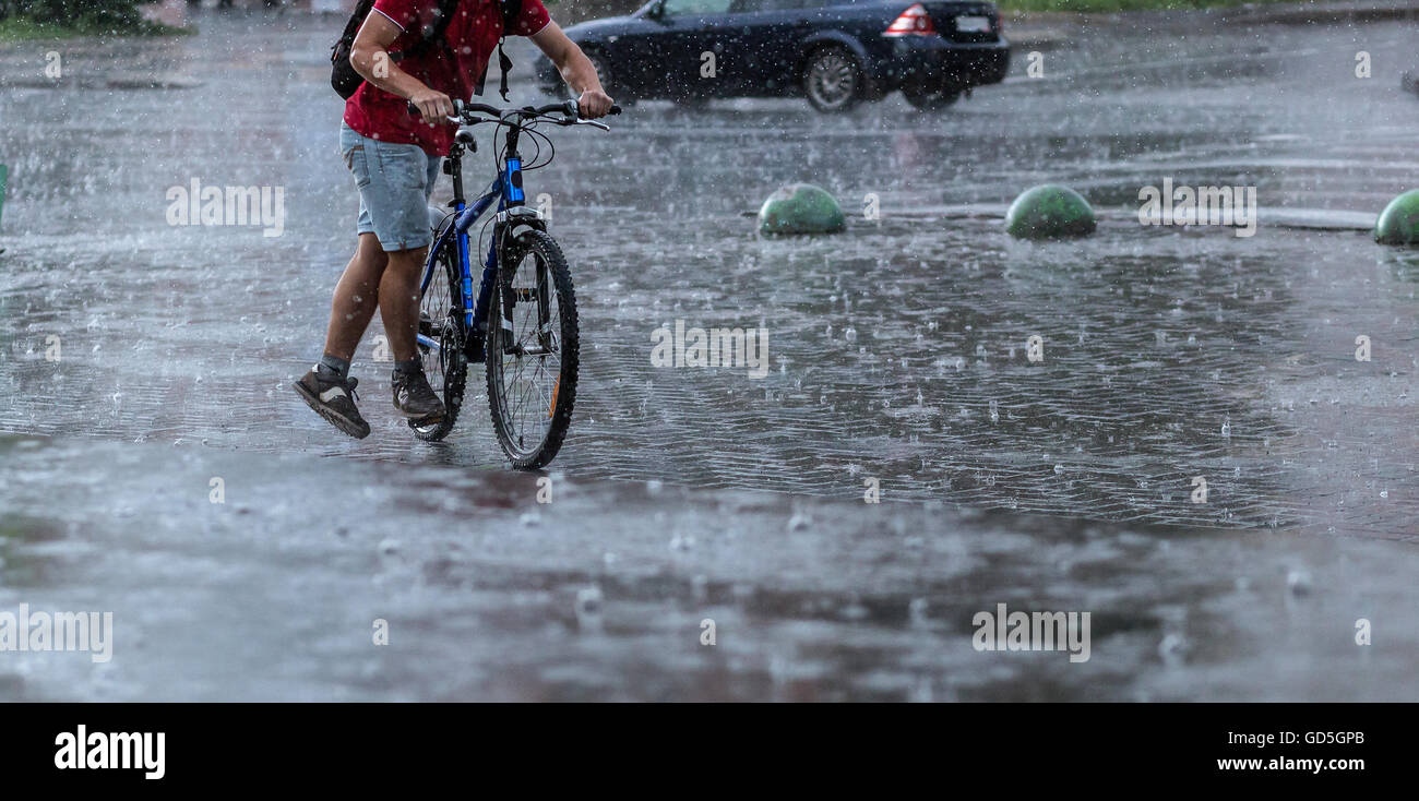 bicycle rider in the rainy city Stock Photo - Alamy