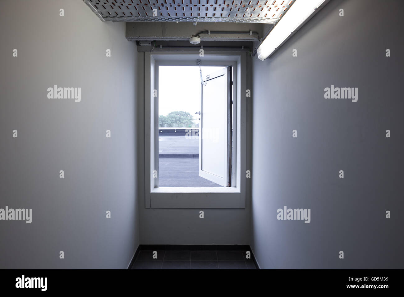 an small emergency exit door at the end of the corridor Stock Photo - Alamy