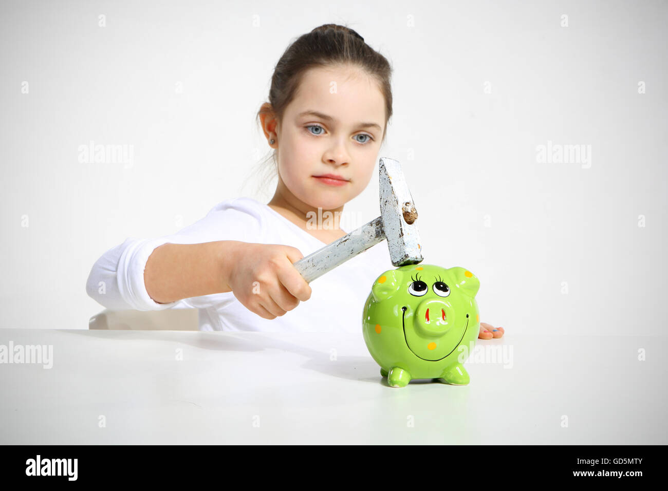 Little girl breaking piggy bank isolated on white Stock Photo - Alamy