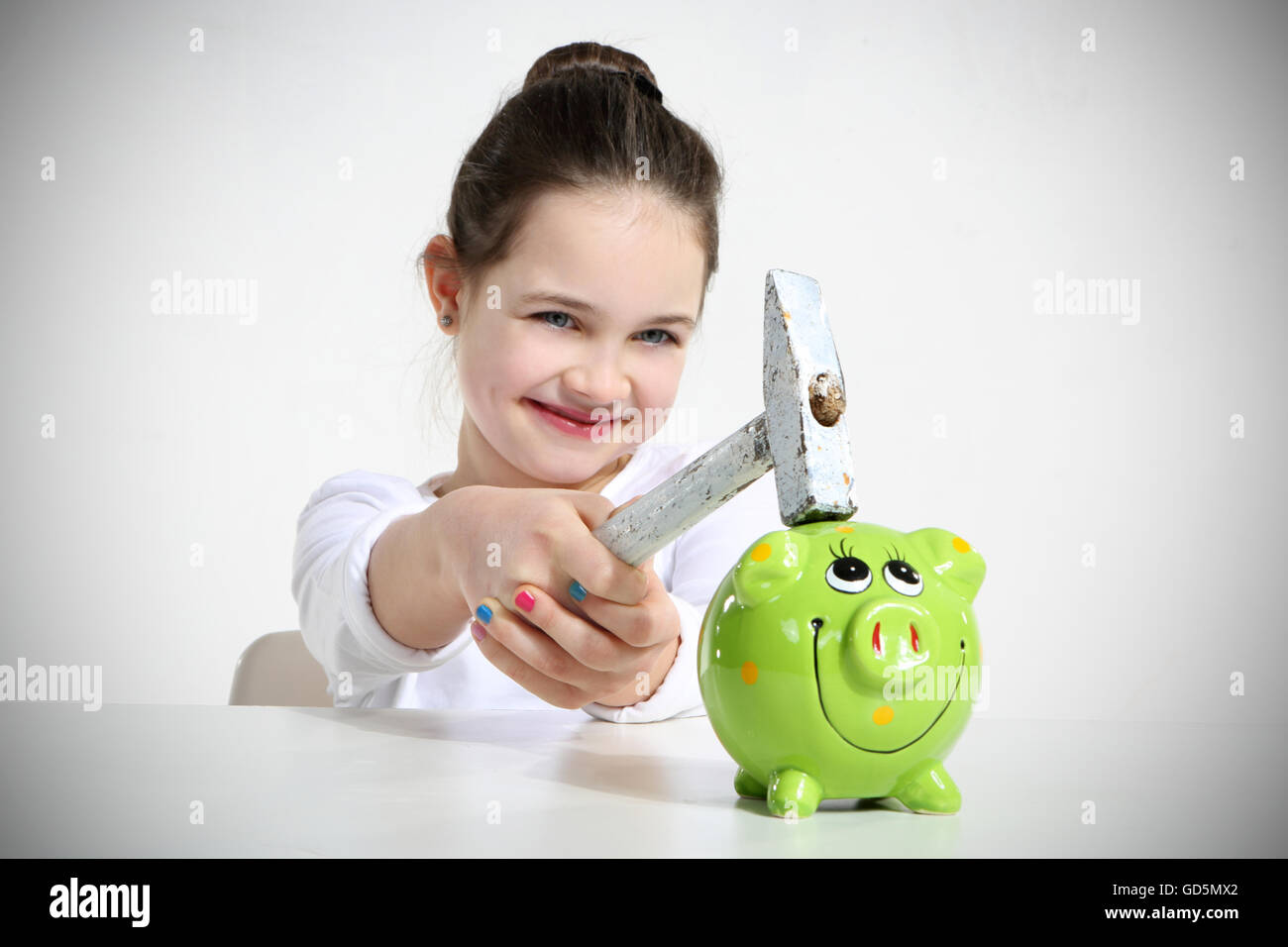 Little girl breaking piggy bank isolated on white Stock Photo - Alamy