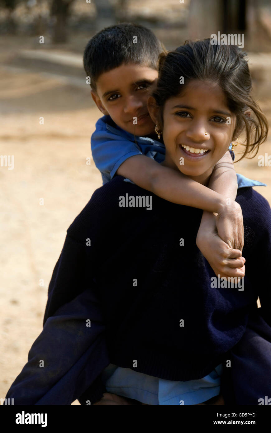Girl carrying her younger brother Stock Photo - Alamy