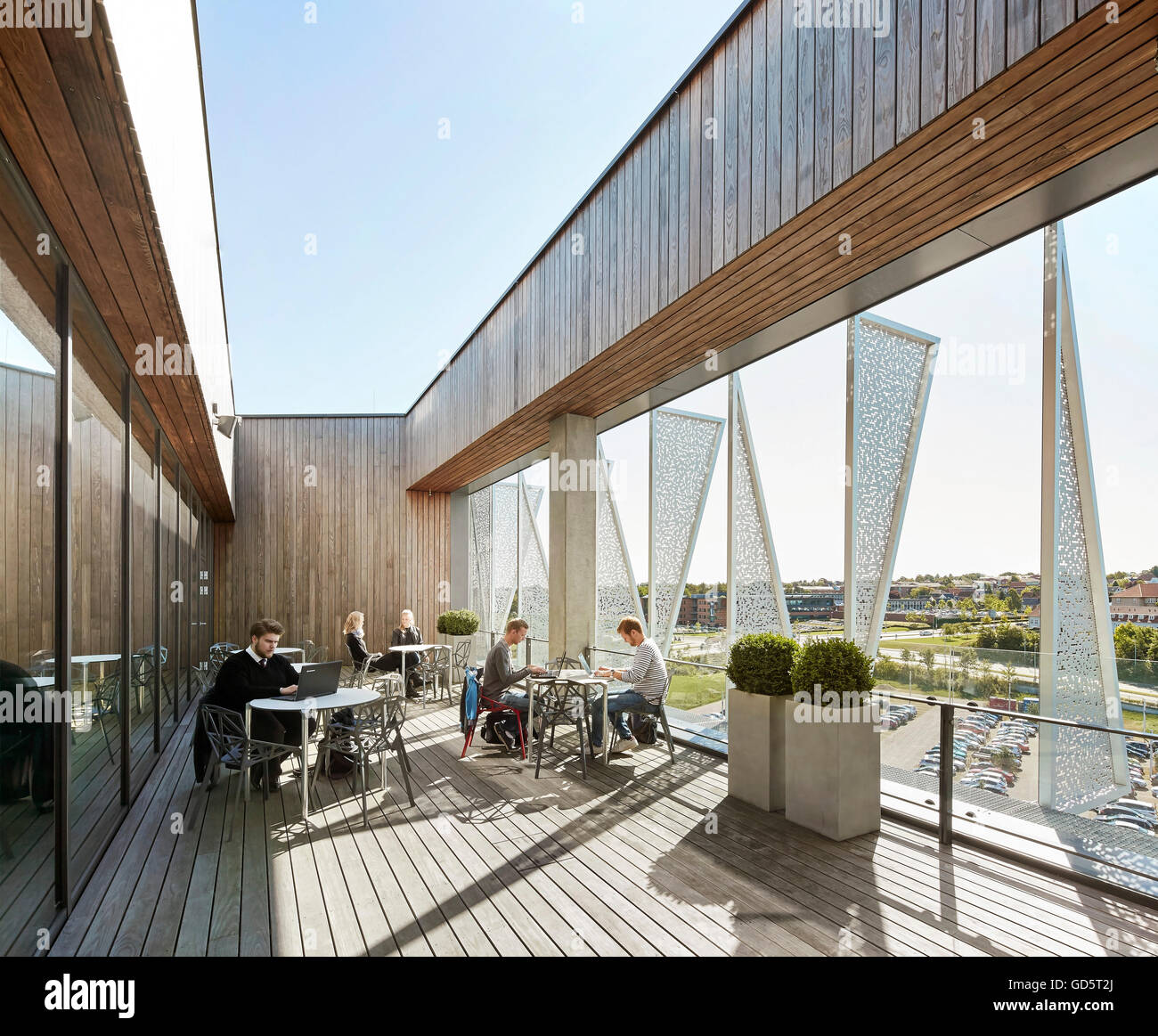 Top floor timber decked terrace. SDU Campus Kolding, Kolding, Denmark. Architect: Henning Larsen ...