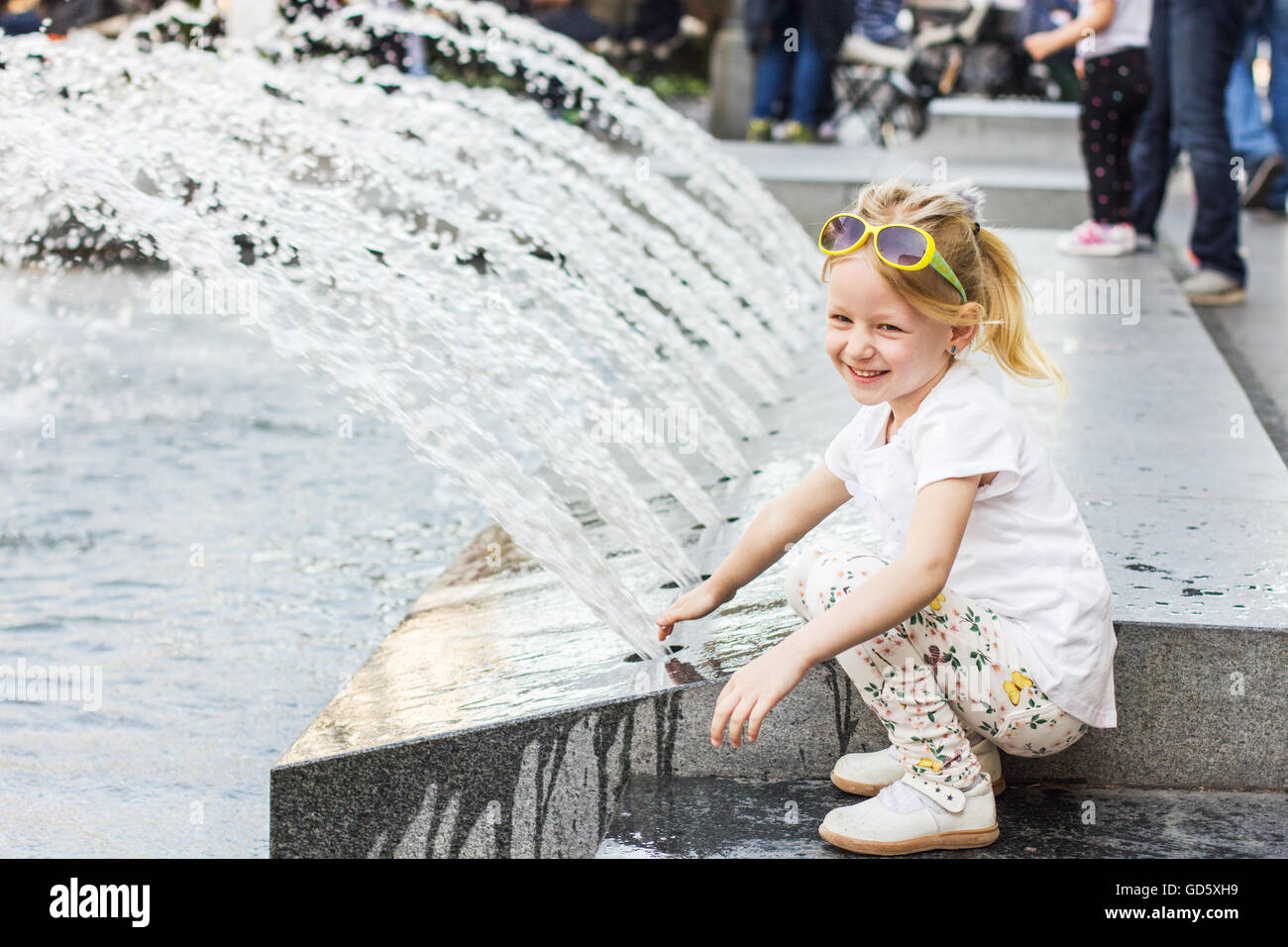 Happy Little girl have fun on city fountain at daylight Stock Photo - Alamy