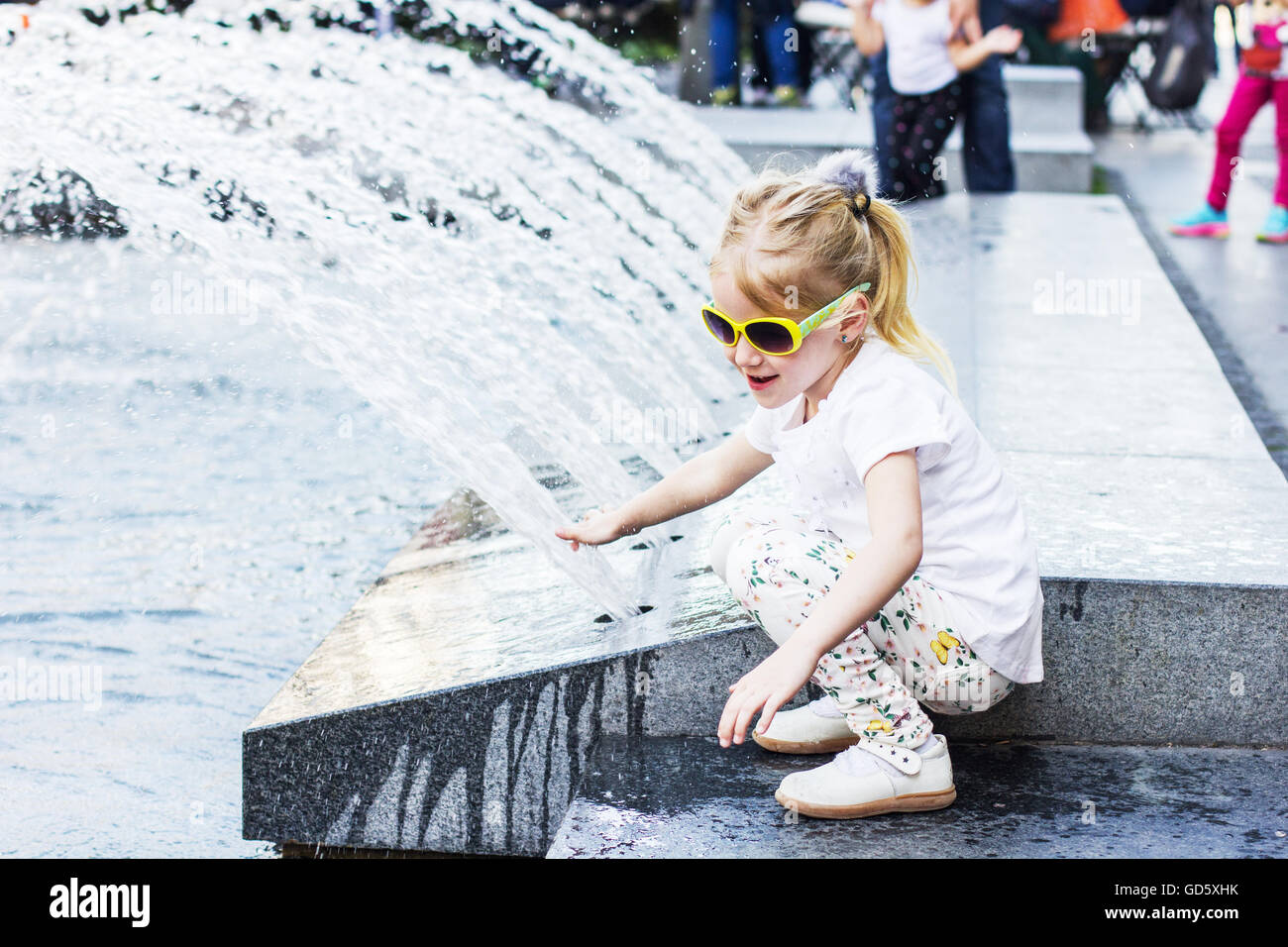 Happy Little girl have fun on city fountain at daylight Stock Photo - Alamy