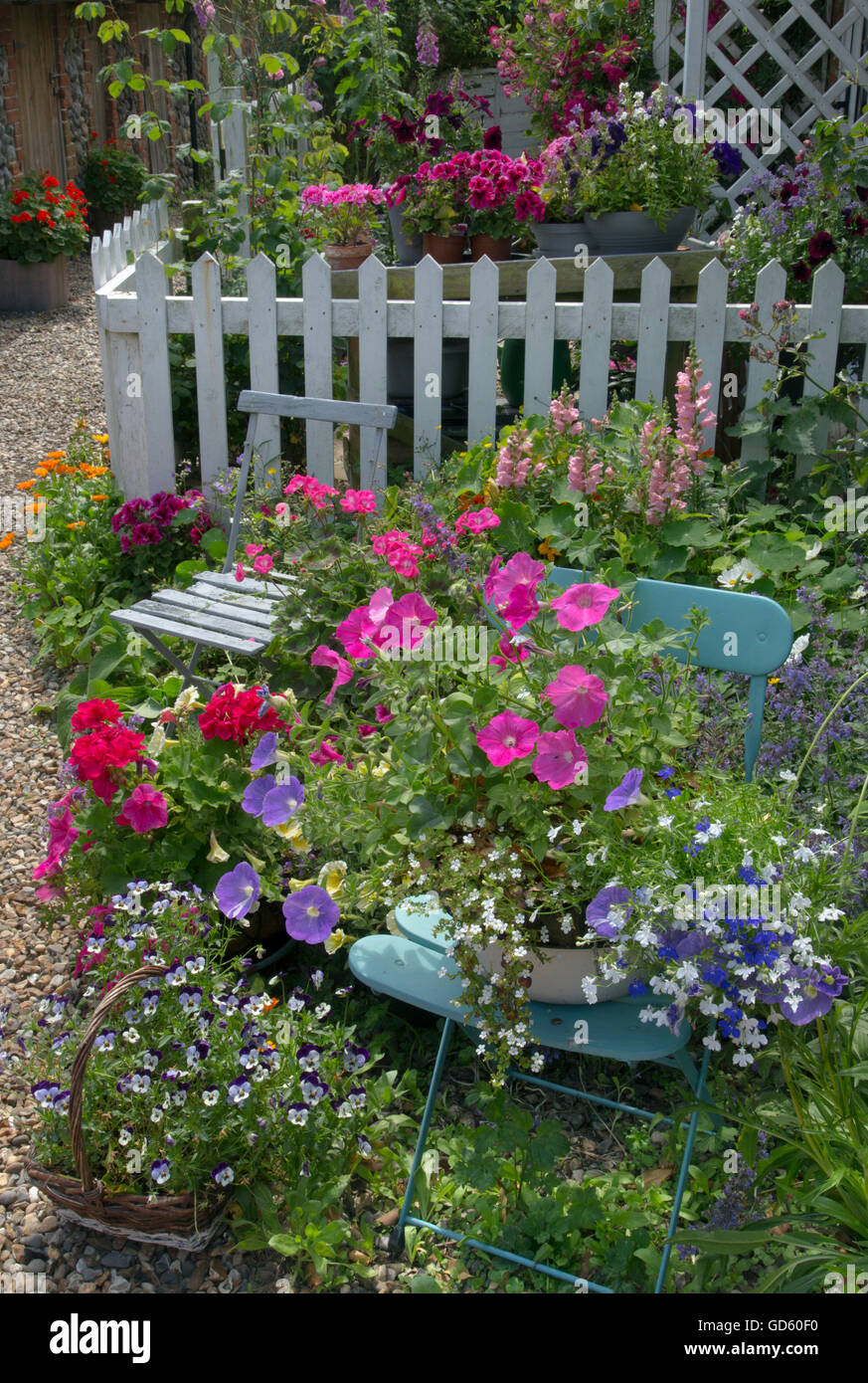 Cottage garden with container planting and blue chairs Stock Photo - Alamy