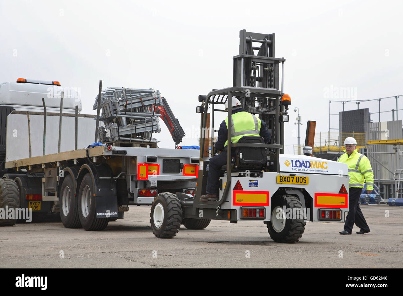 A lorry-mounted fork-lift truck detaches itself from the trailer during ...