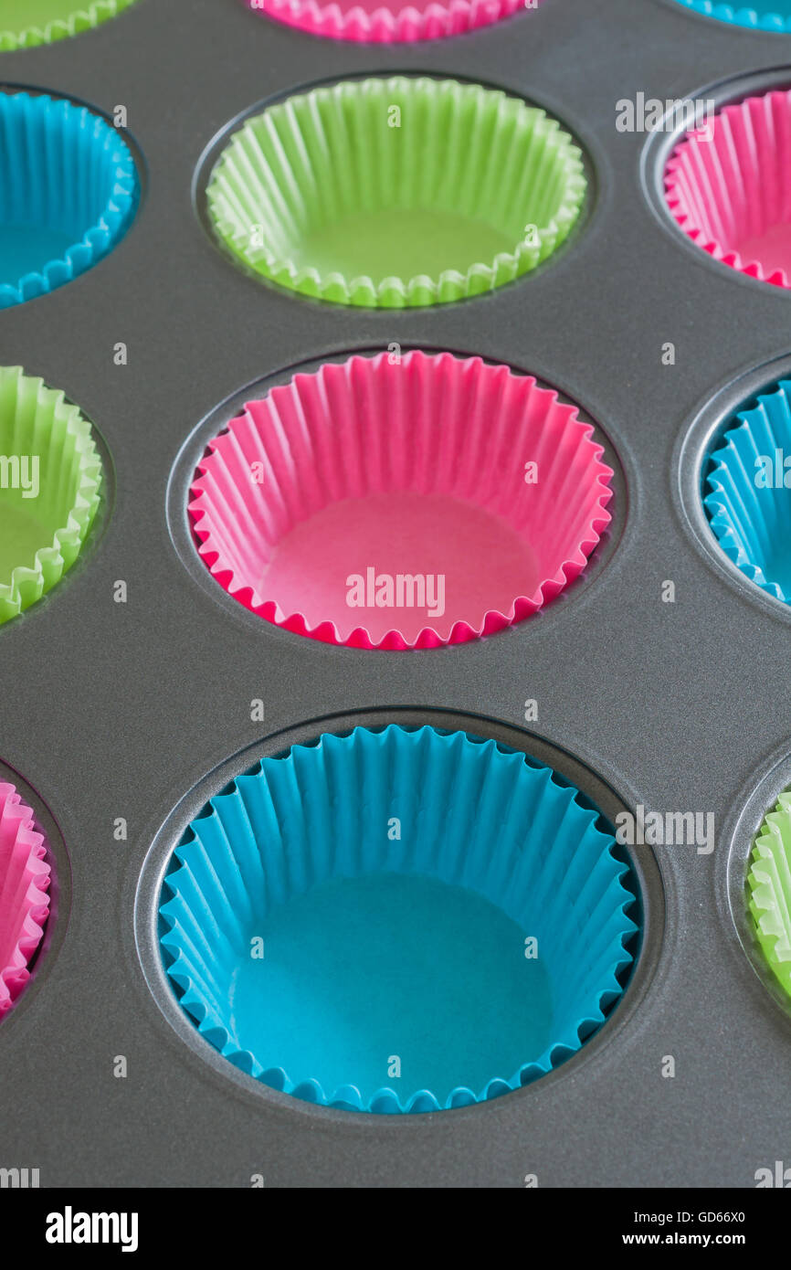 Cake or muffin tin with colourful paper cases useful for baking ...