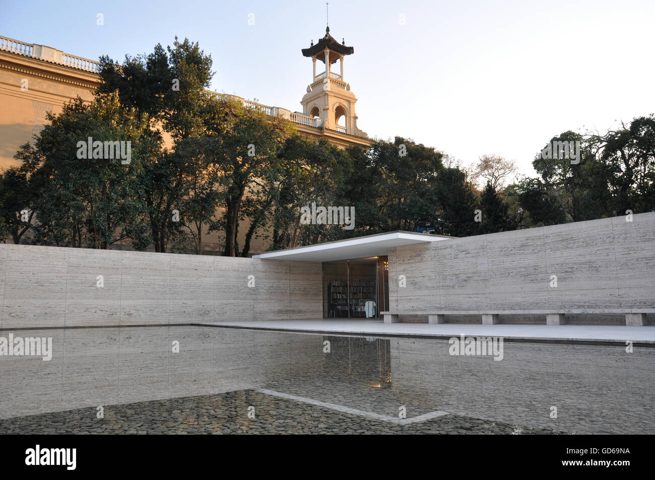 German Pavilion in Barcelona with large reflecting pool and trees lined ...
