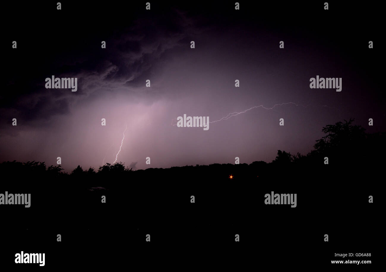 Lightening in the night, heavy clouds are illuminated by the lightening ...