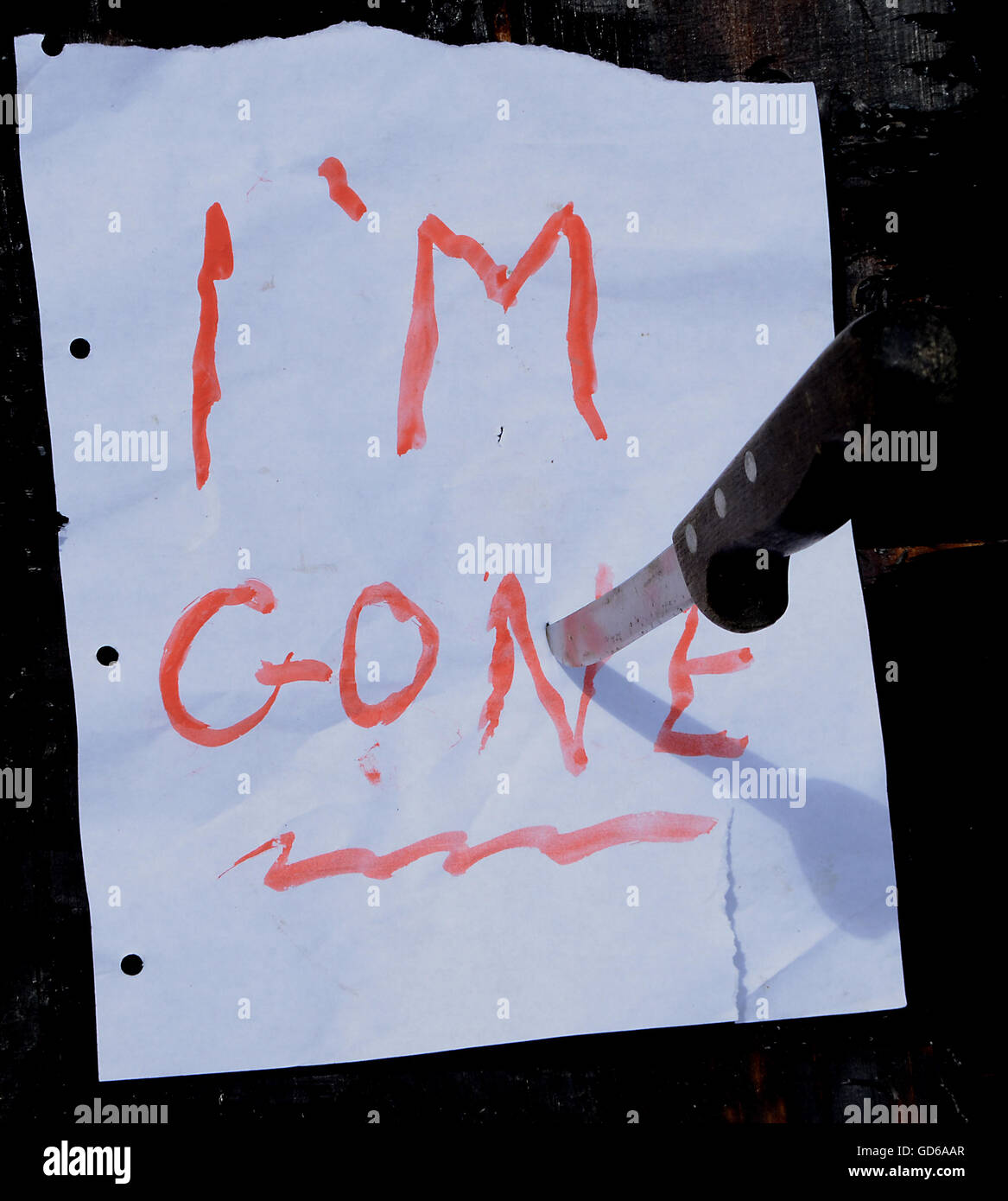 Paper with the text I'm Gone nailed to a burned surface with a large ...