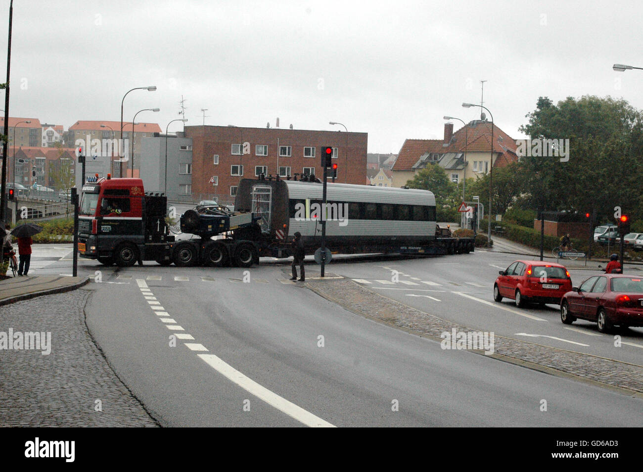 Heavy load truck backs out in a crossing, the truck has a railway car ...