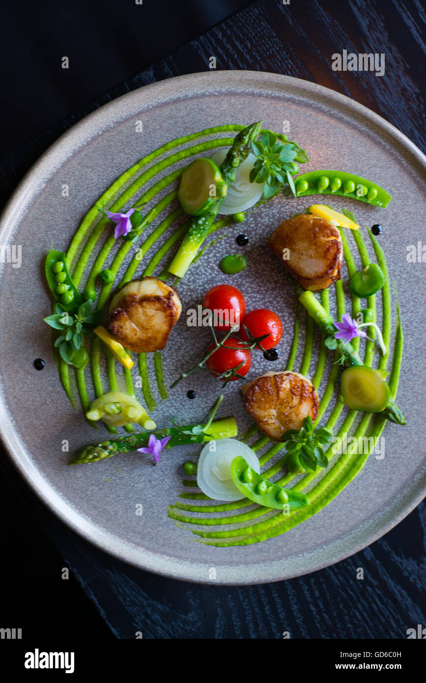 Overhead view of a seasonal vegetable medley with scallops and pea ...
