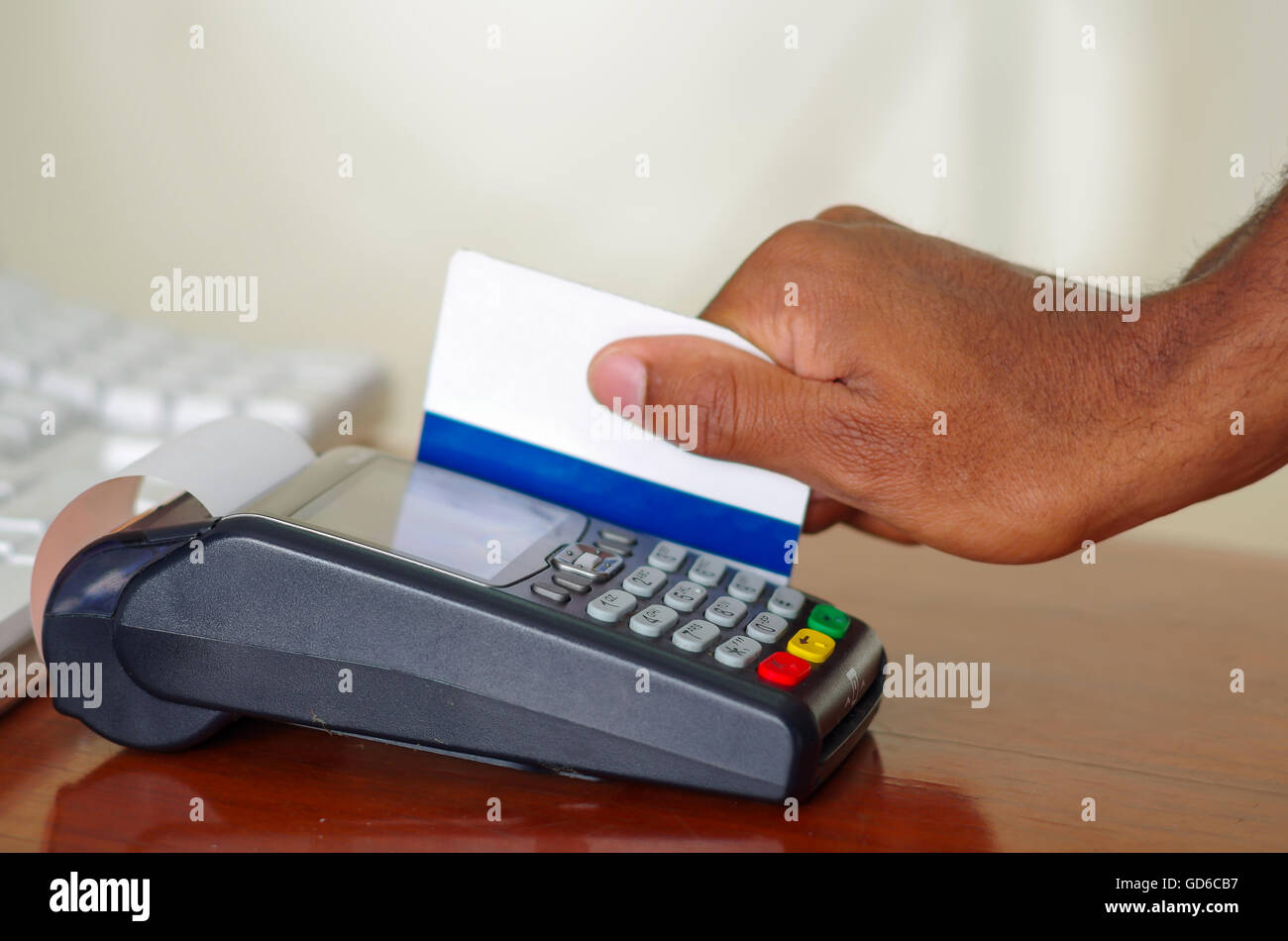 Closeup hand swiping credit card through payment terminal device ...