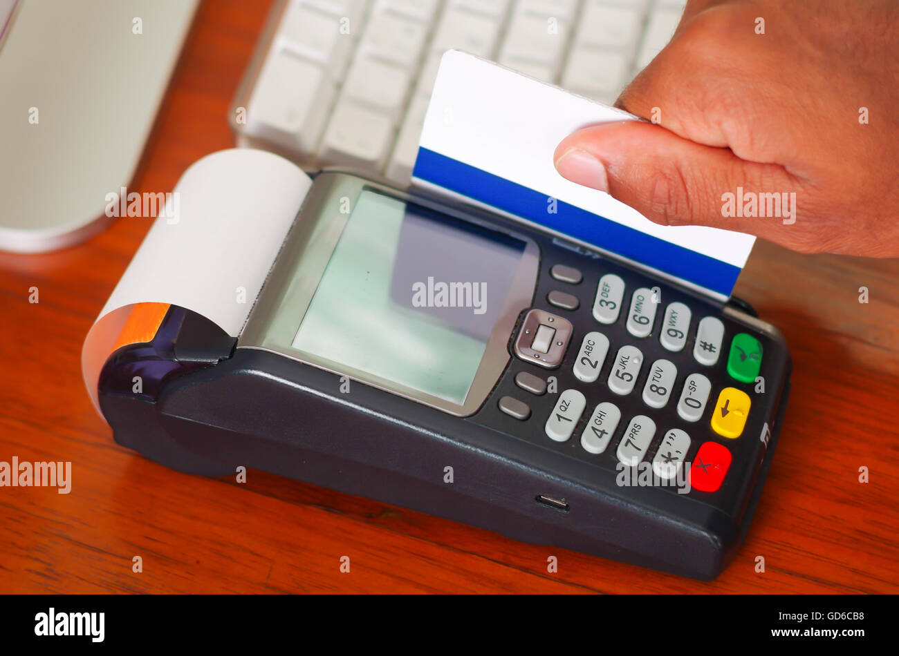 Closeup hand swiping credit card through payment terminal device ...