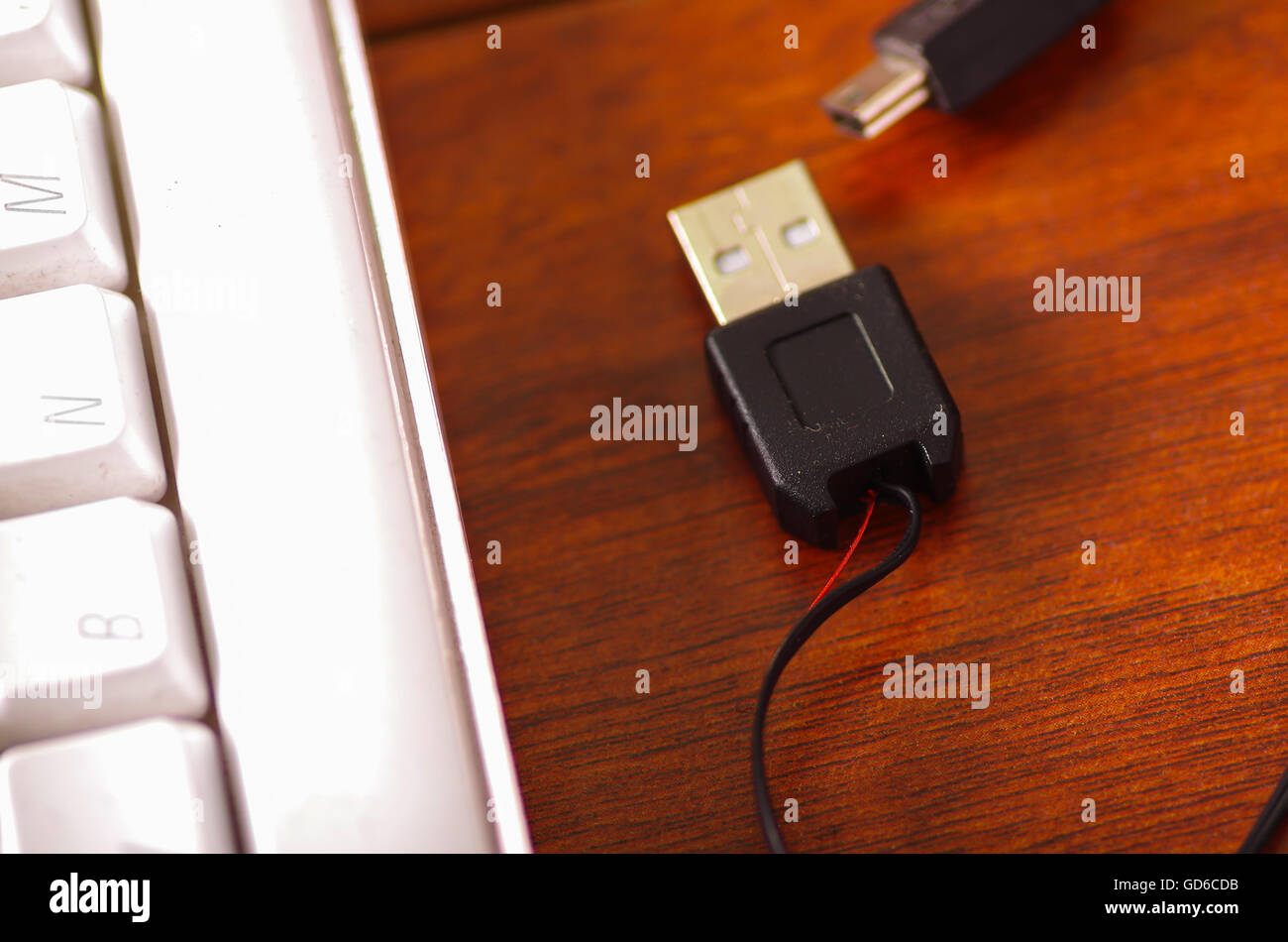 Broken usb mobile charger cable lying on wooden surface, part of ...