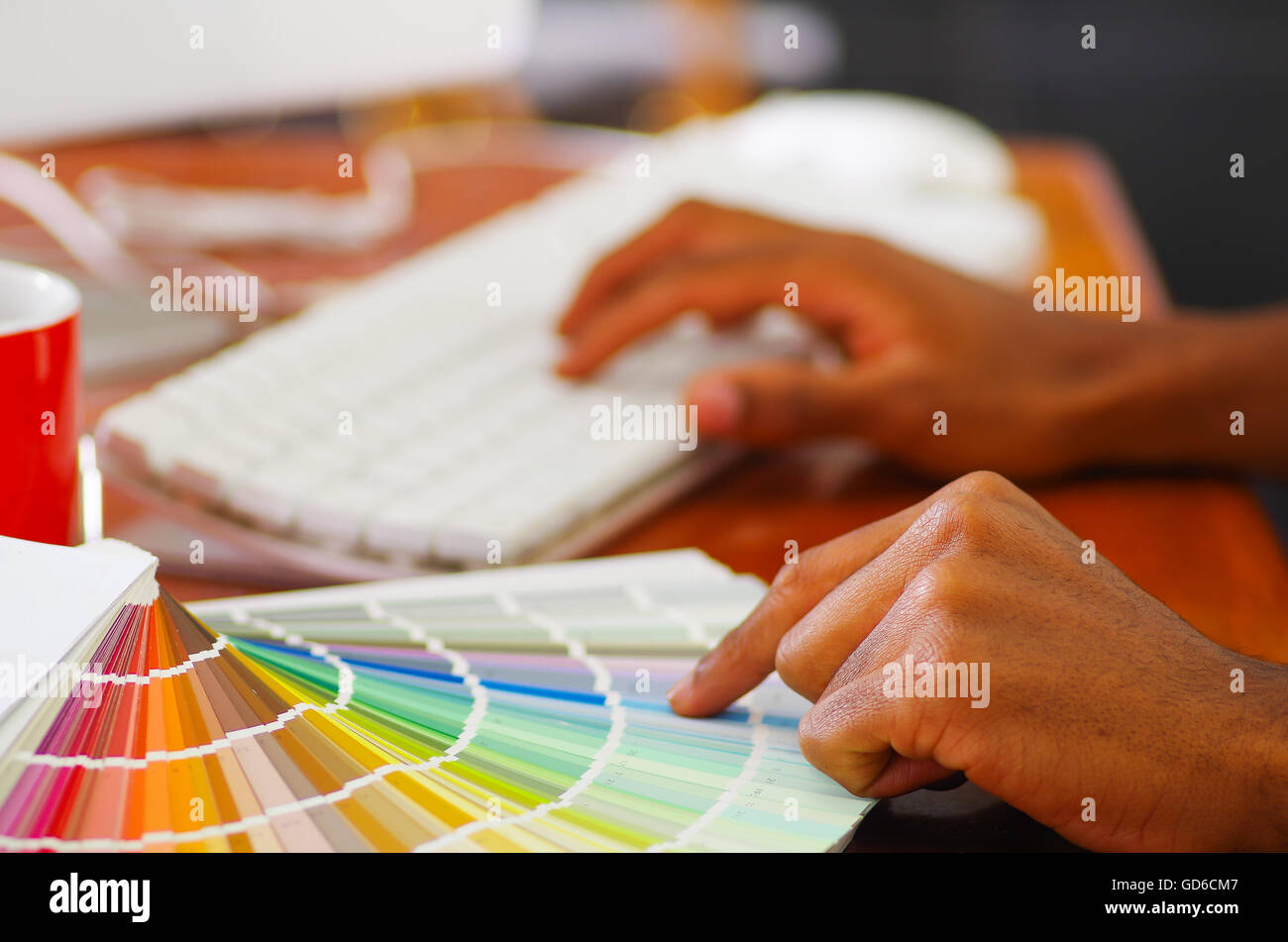Closeup hands holding palette, colormap spread out in front of white ...