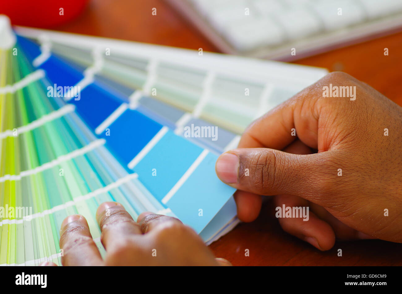 Closeup hands holding palette, colormap spread out in front of white ...