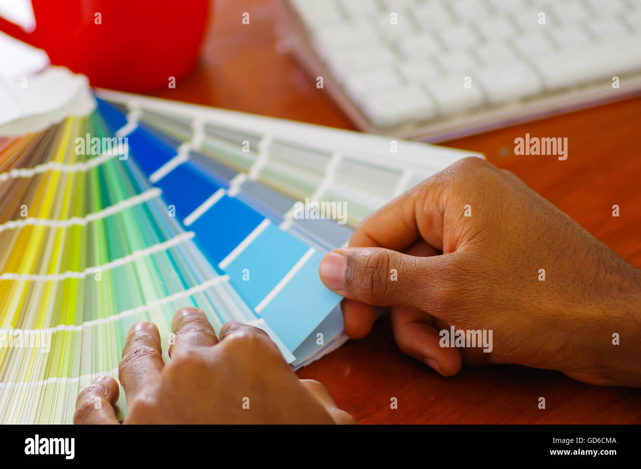 Closeup hands holding palette, colormap spread out in front of white ...