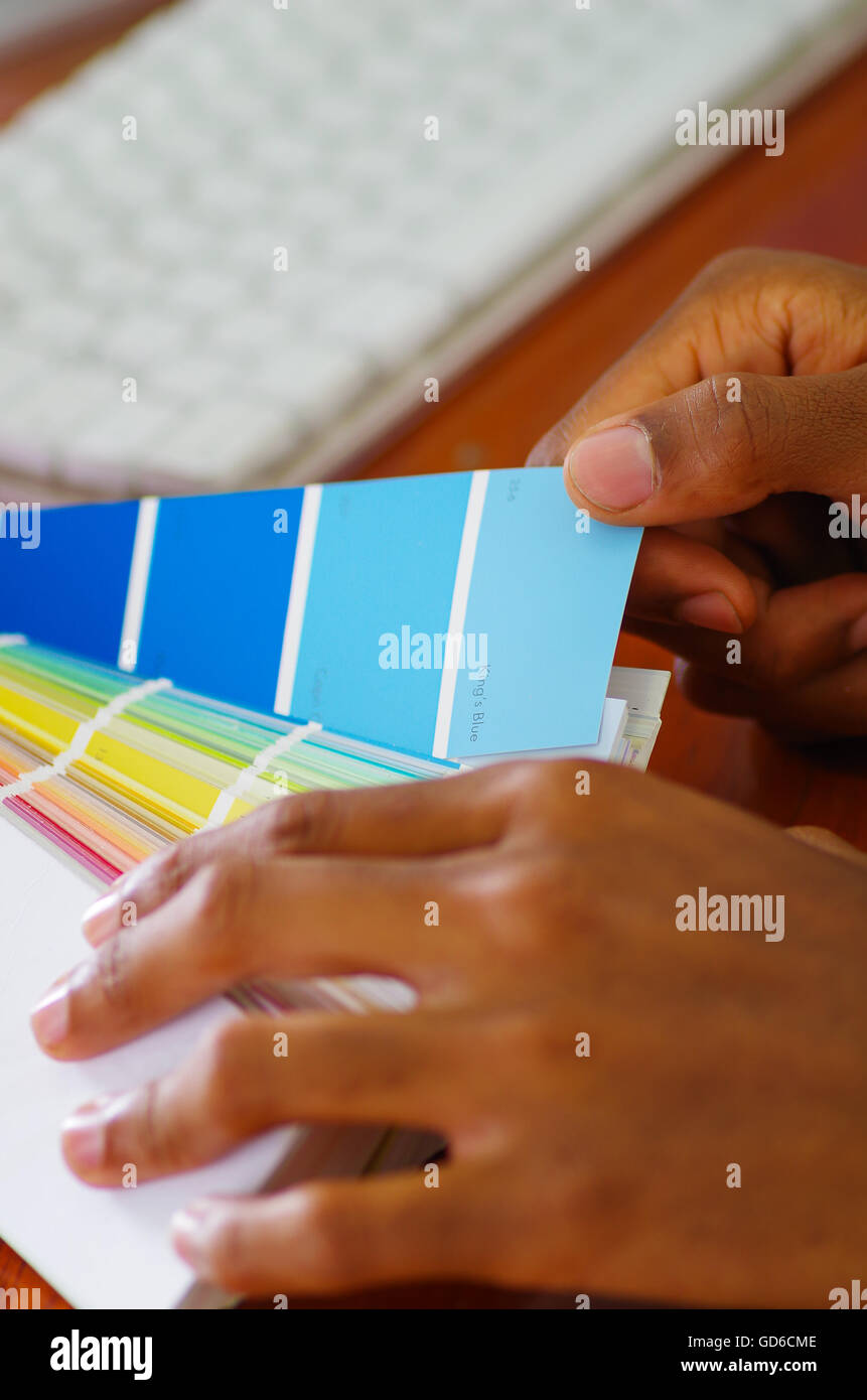 Closeup hands holding palette, colormap spread out in front of white ...