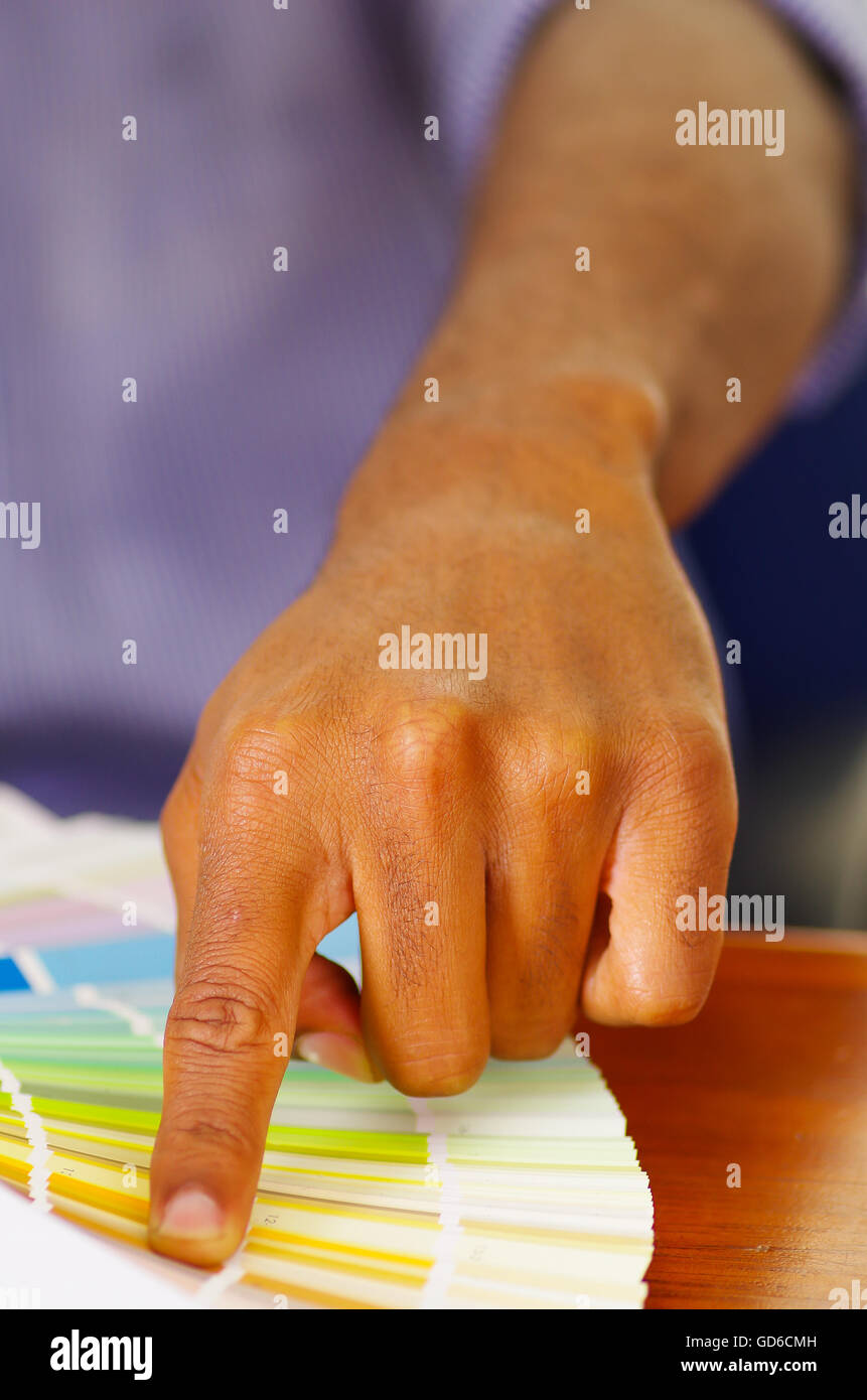 Closeup hands holding palette, colormap spread out in front of white ...