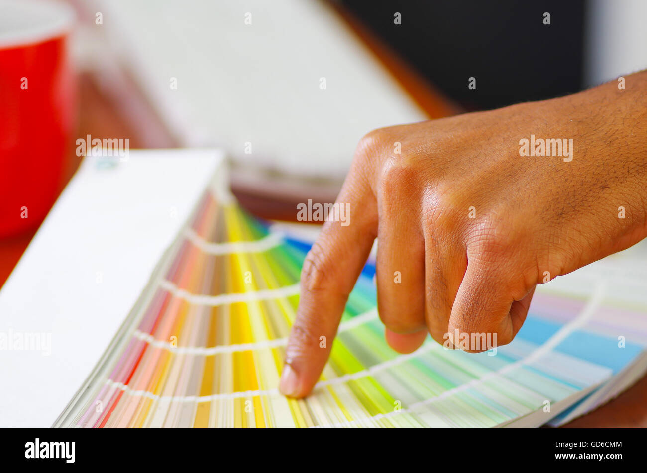 Closeup hands holding palette, colormap spread out in front of white ...