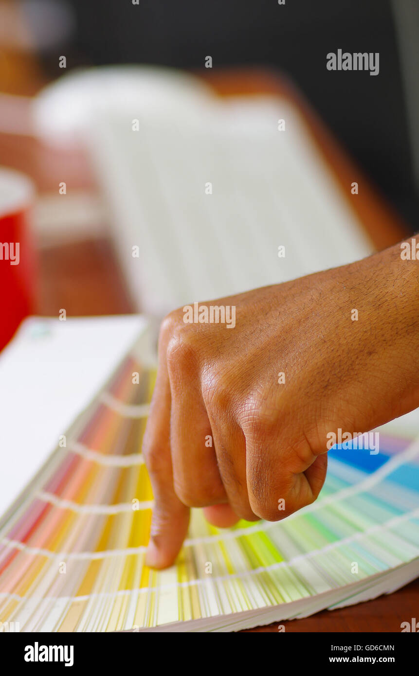Closeup hands holding palette, colormap spread out in front of white ...
