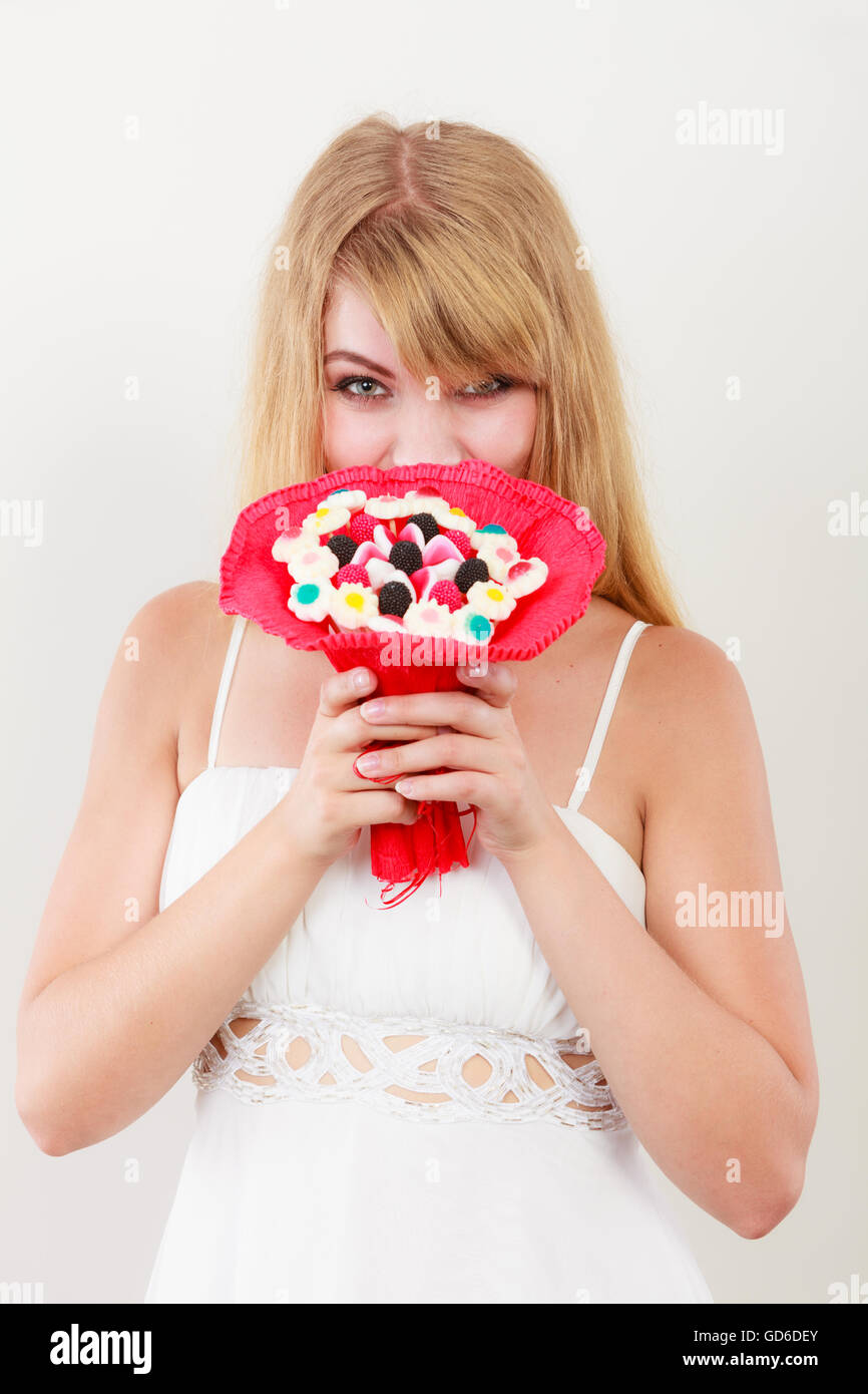 Pretty happy woman with candy bunch bouquet flowers. Gorgeous young ...