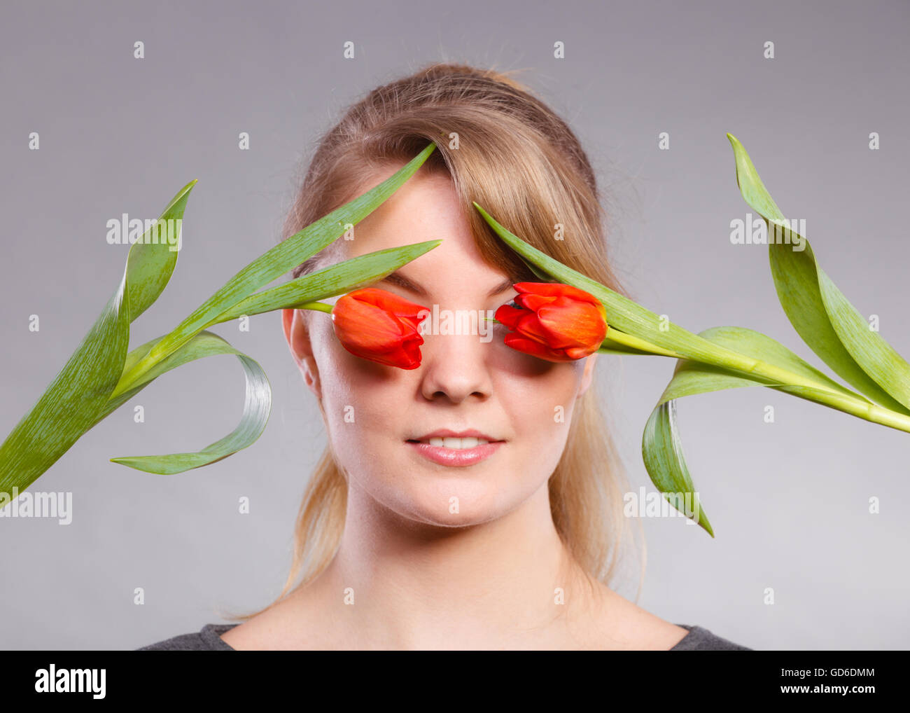 People and nature. Young woman with tulip on her face live in peace ...